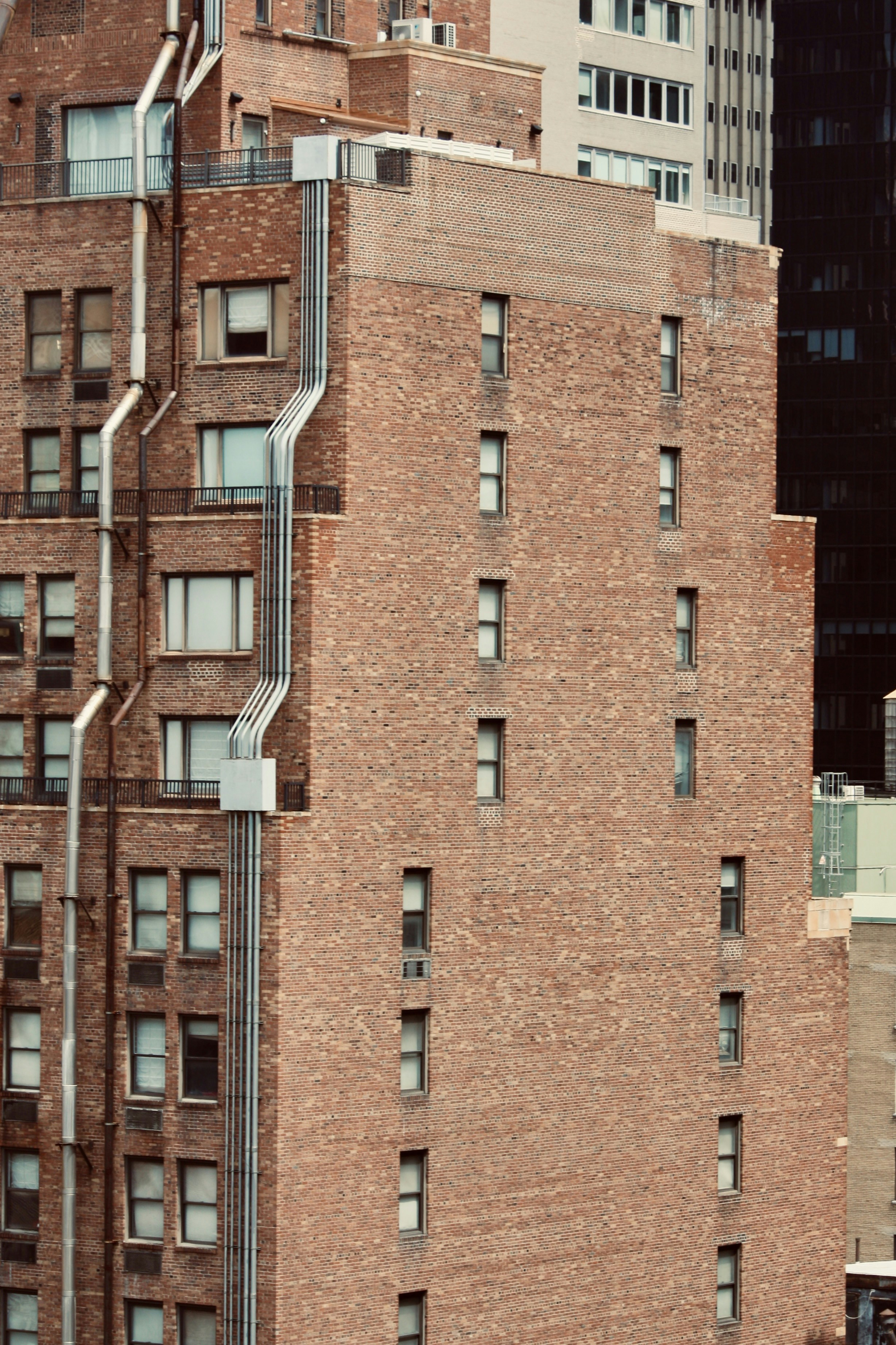 Tall brick buildings with many windows in a city.