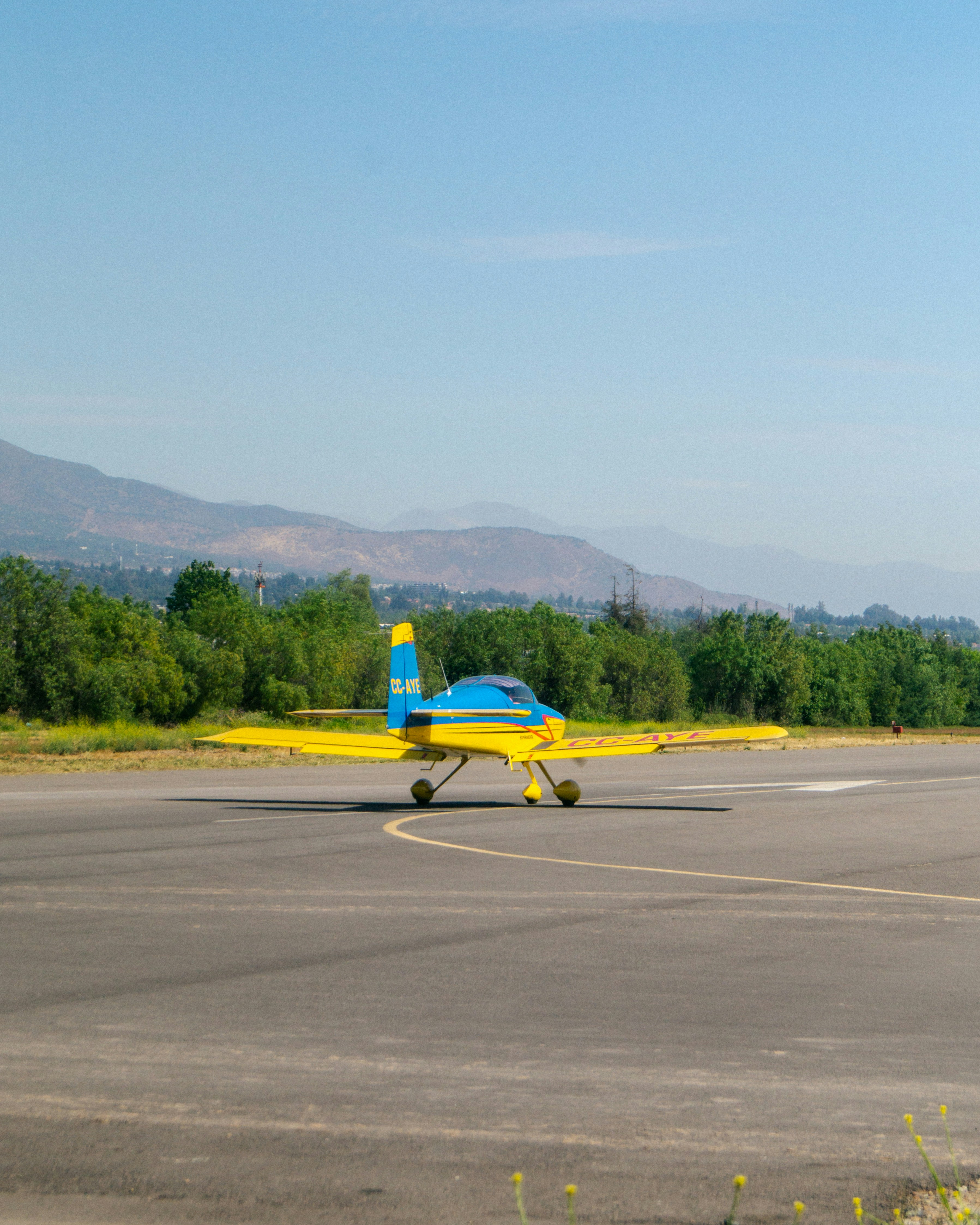 A yellow and blue airplane on a tarmac.
