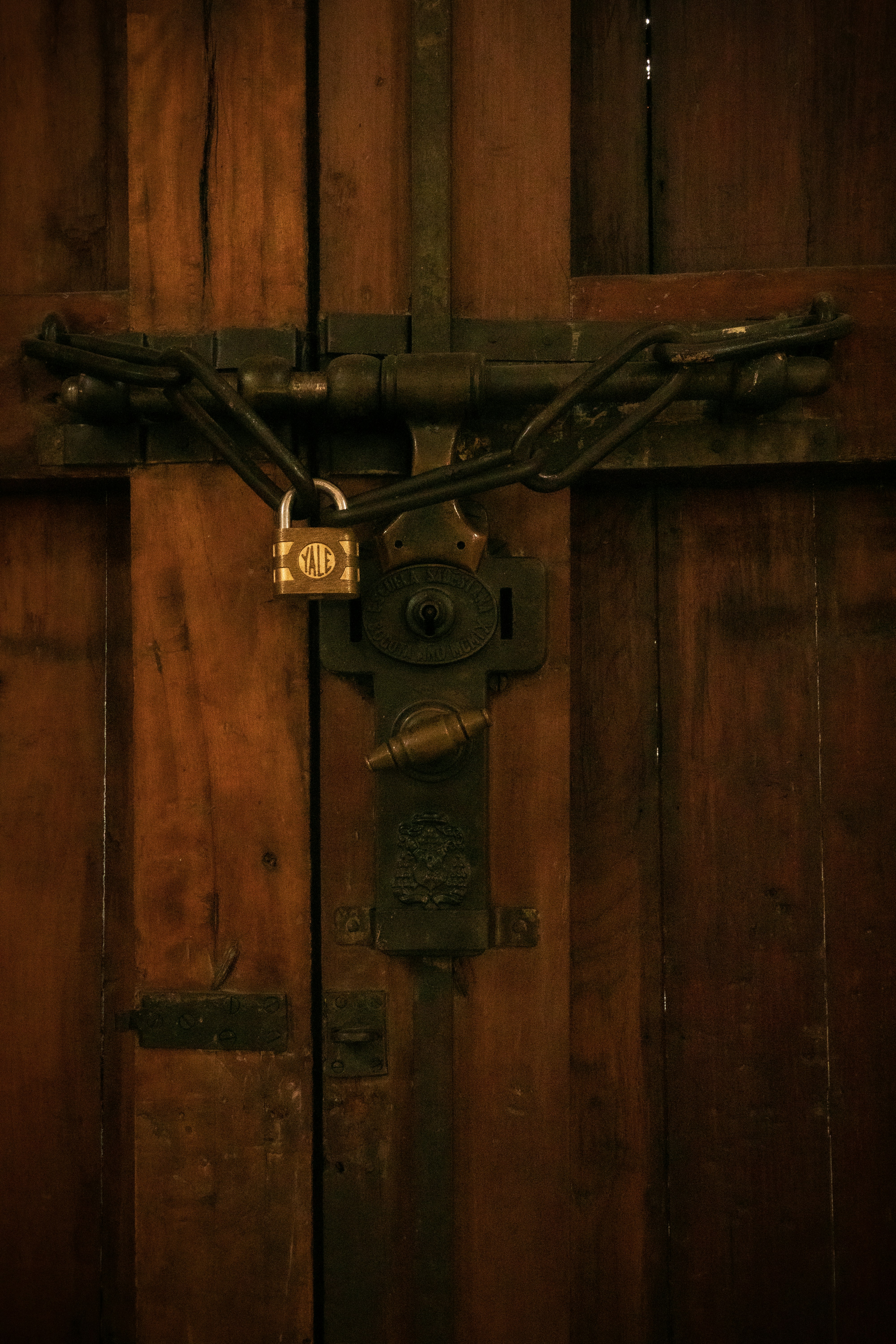 Old wooden door secured with a padlock and chain