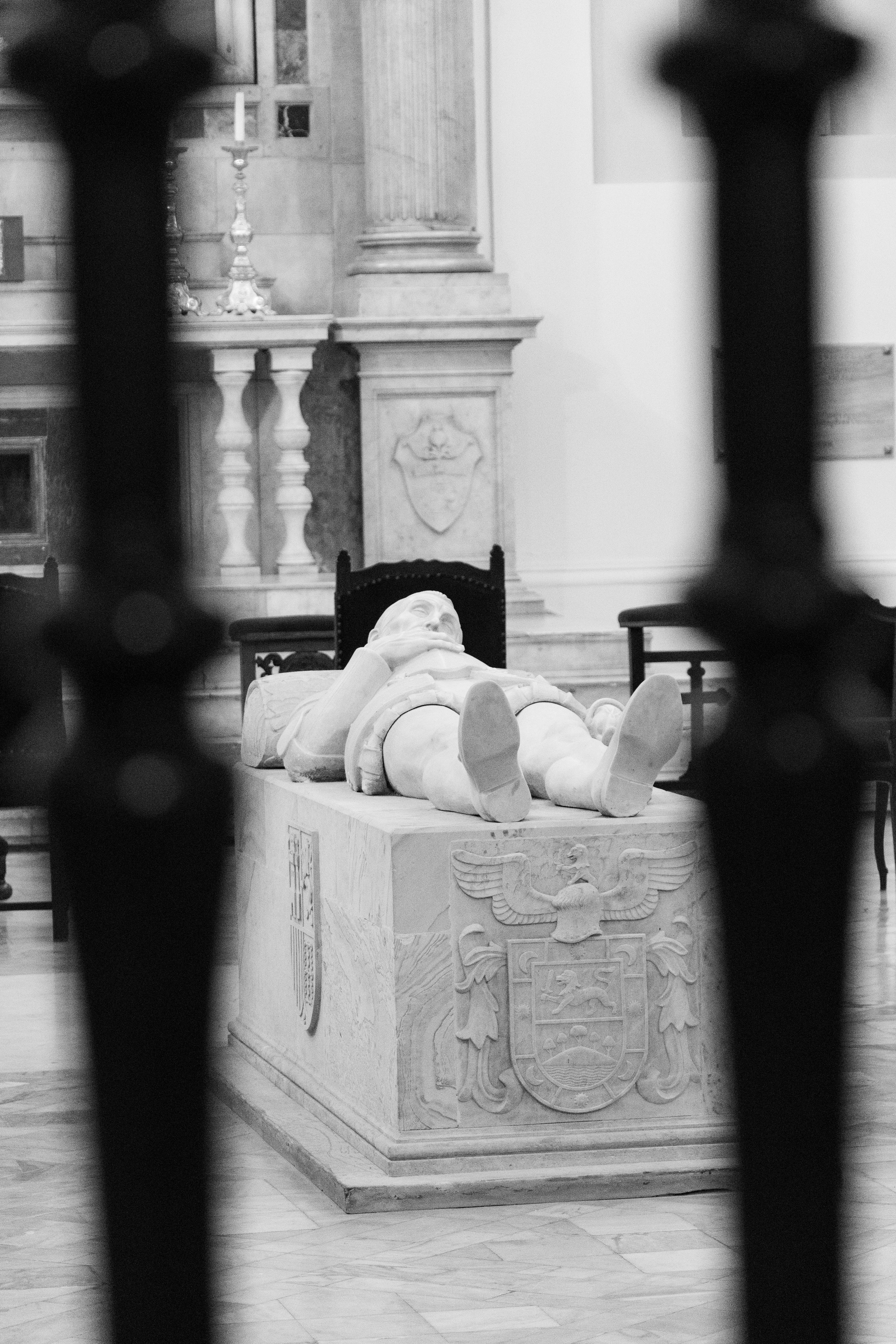 Stone effigy of a person lying on a tomb.