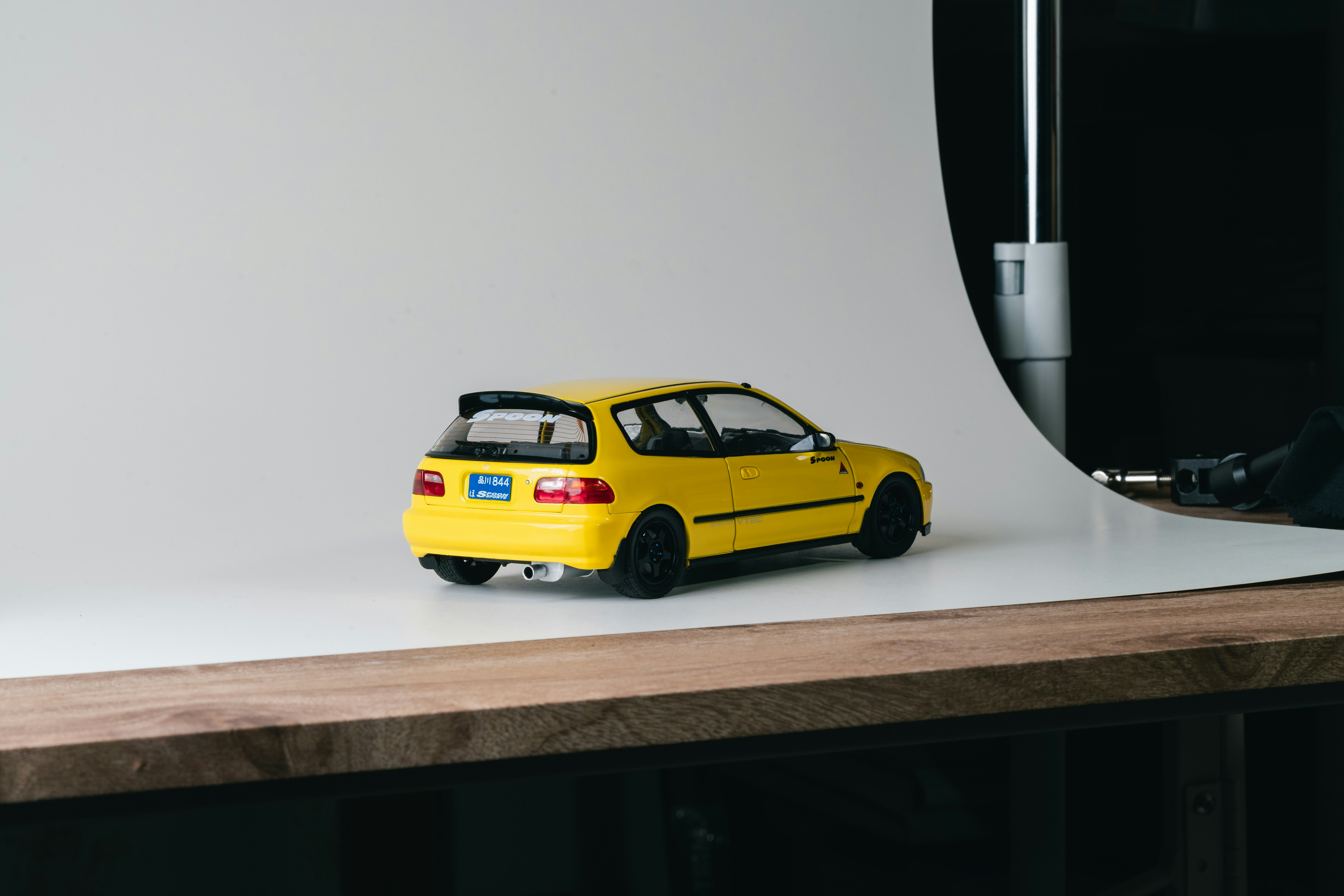 Yellow toy car on a white surface.
