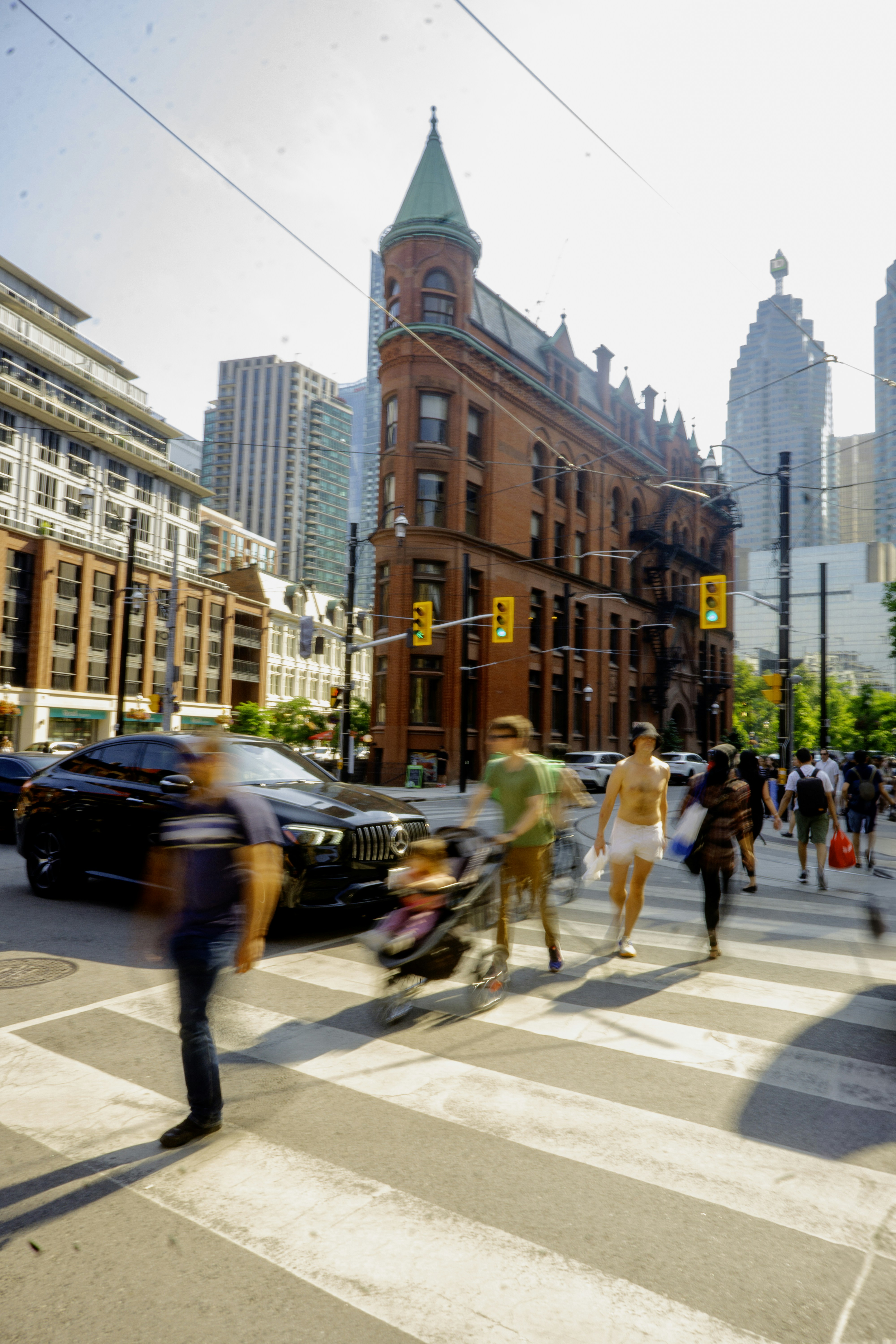 Long exposure street shot of the Gooderham building in Toronto | People crossing street in front of flatiron building.
