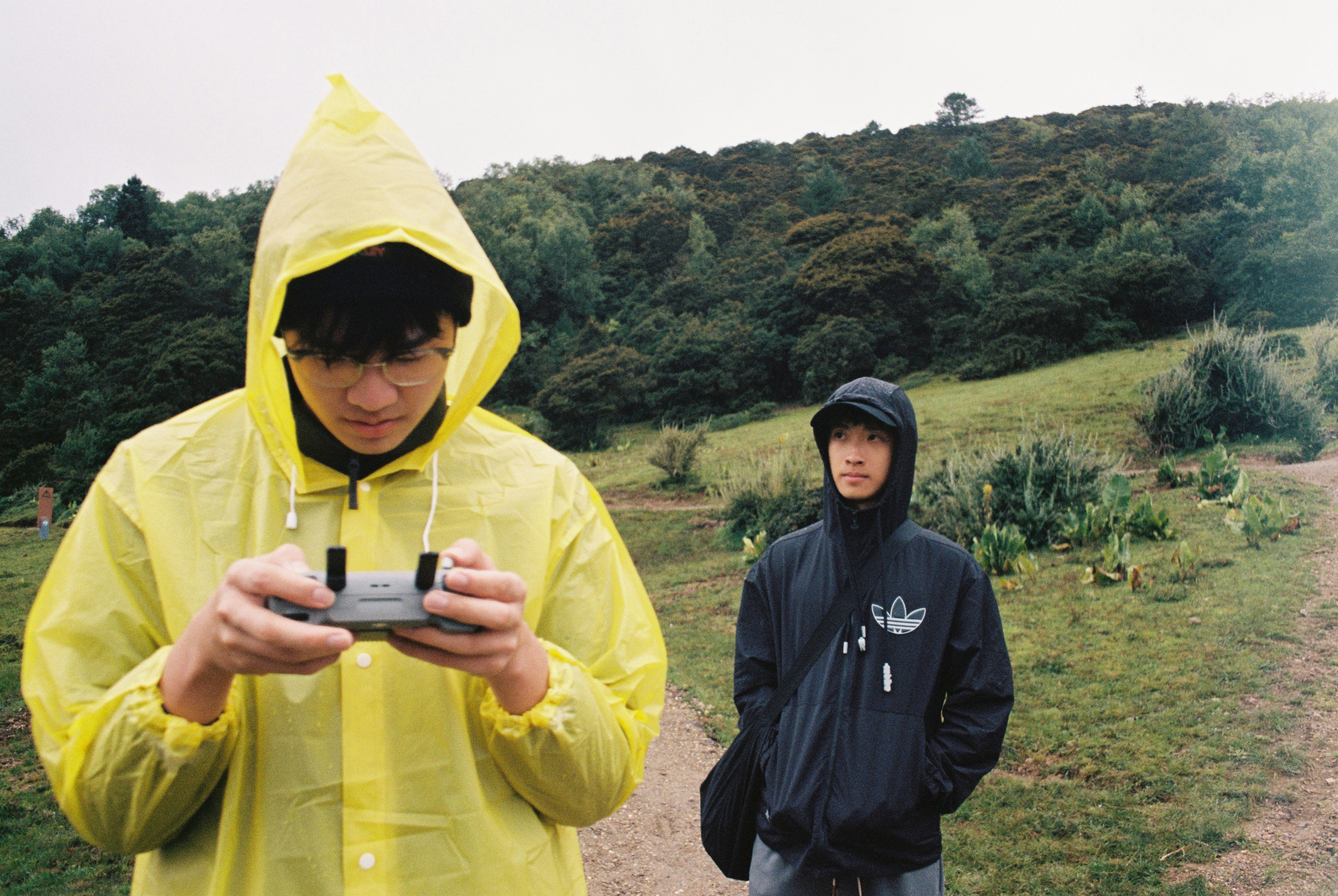 Kodak Portra 400 | Two people in raincoats in a hilly, wooded area.