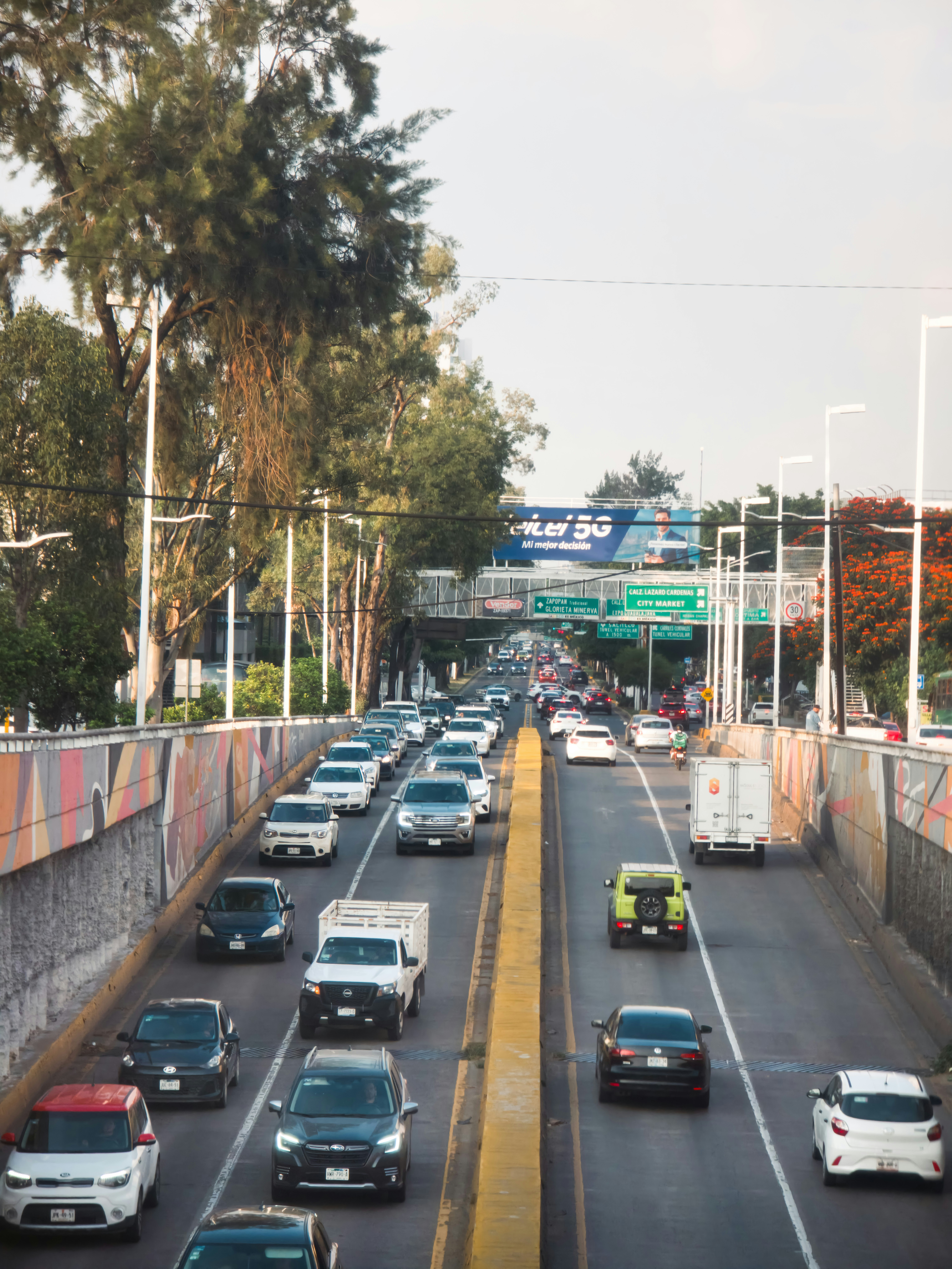 Heavy traffic on a multi-lane highway with trees.