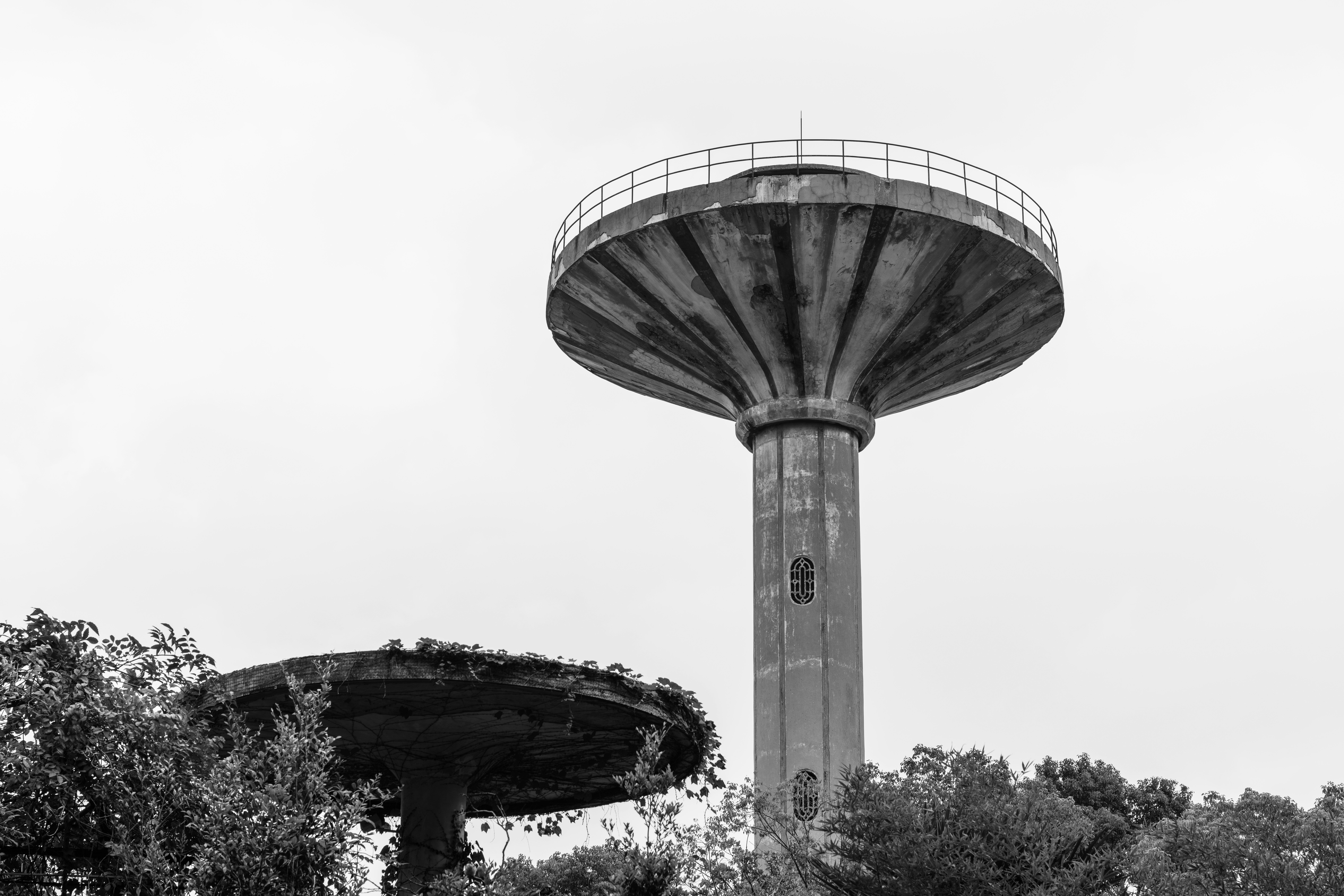 Two concrete water towers against a cloudy sky