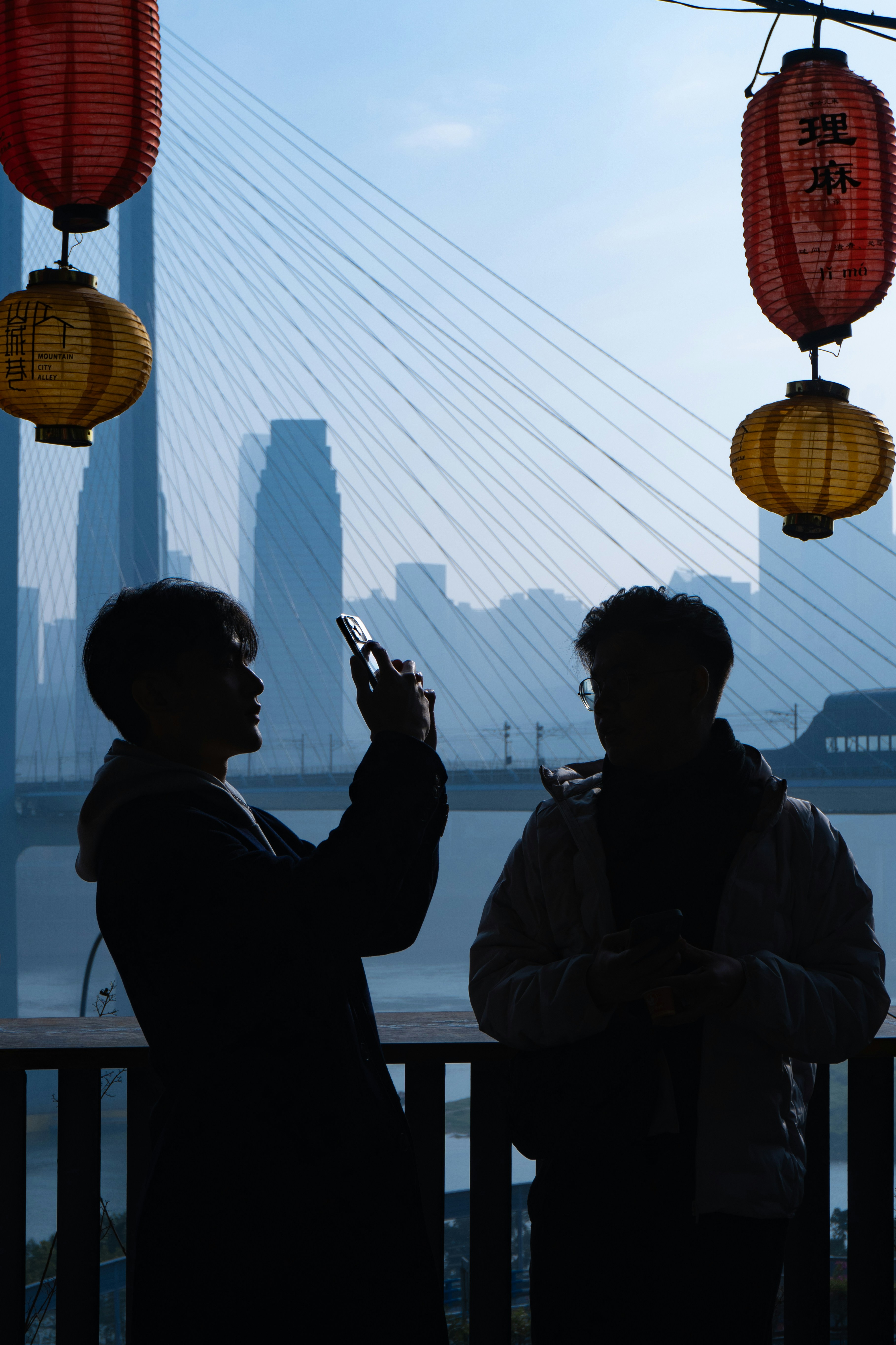 meet my friends ! | Two people silhouetted against a cityscape and bridge.