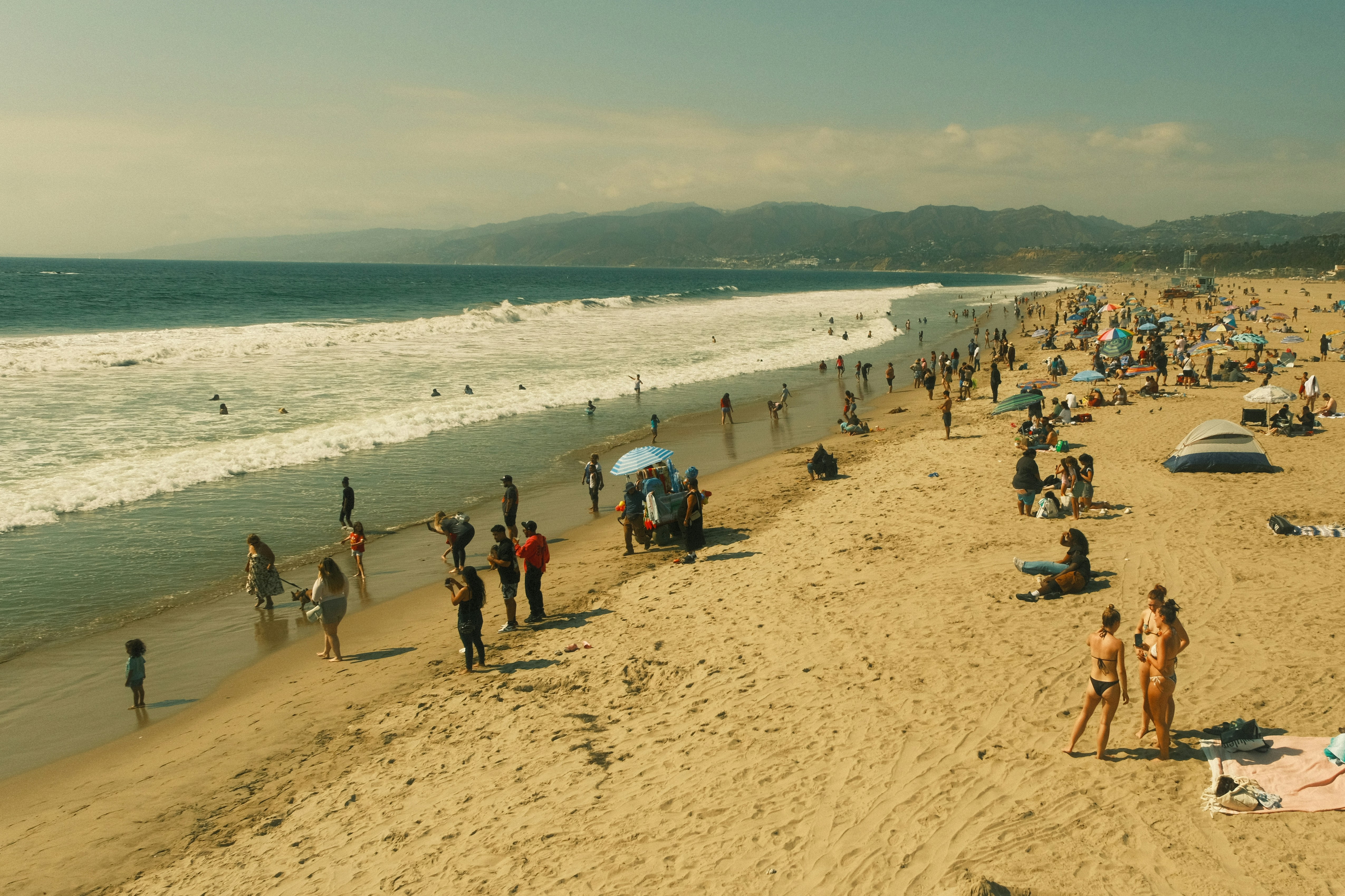 Crowded beach with people enjoying the ocean and sand. photo – Free ...