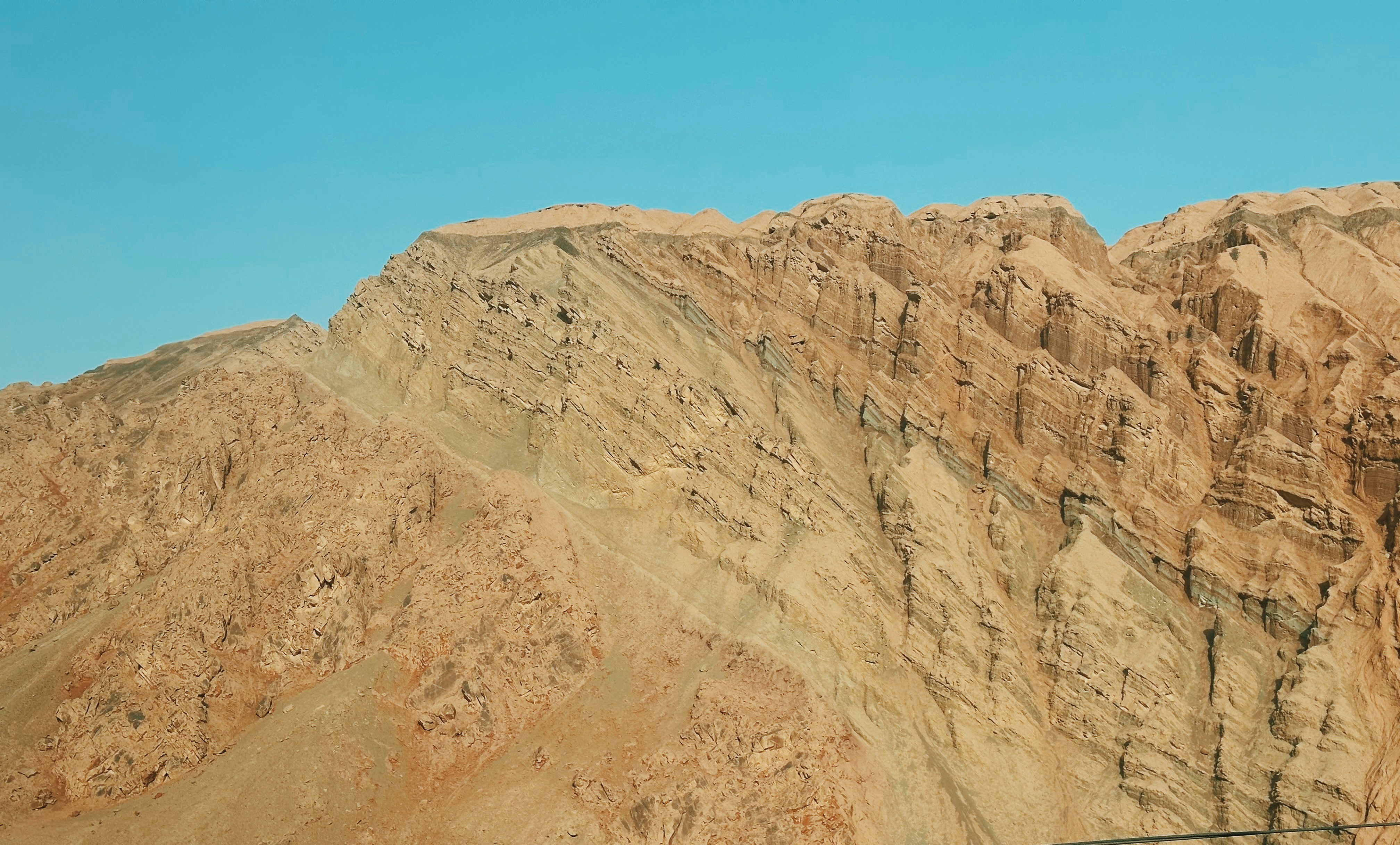 Striking geological formations showcasing layered rock structures under a clear blue sky.