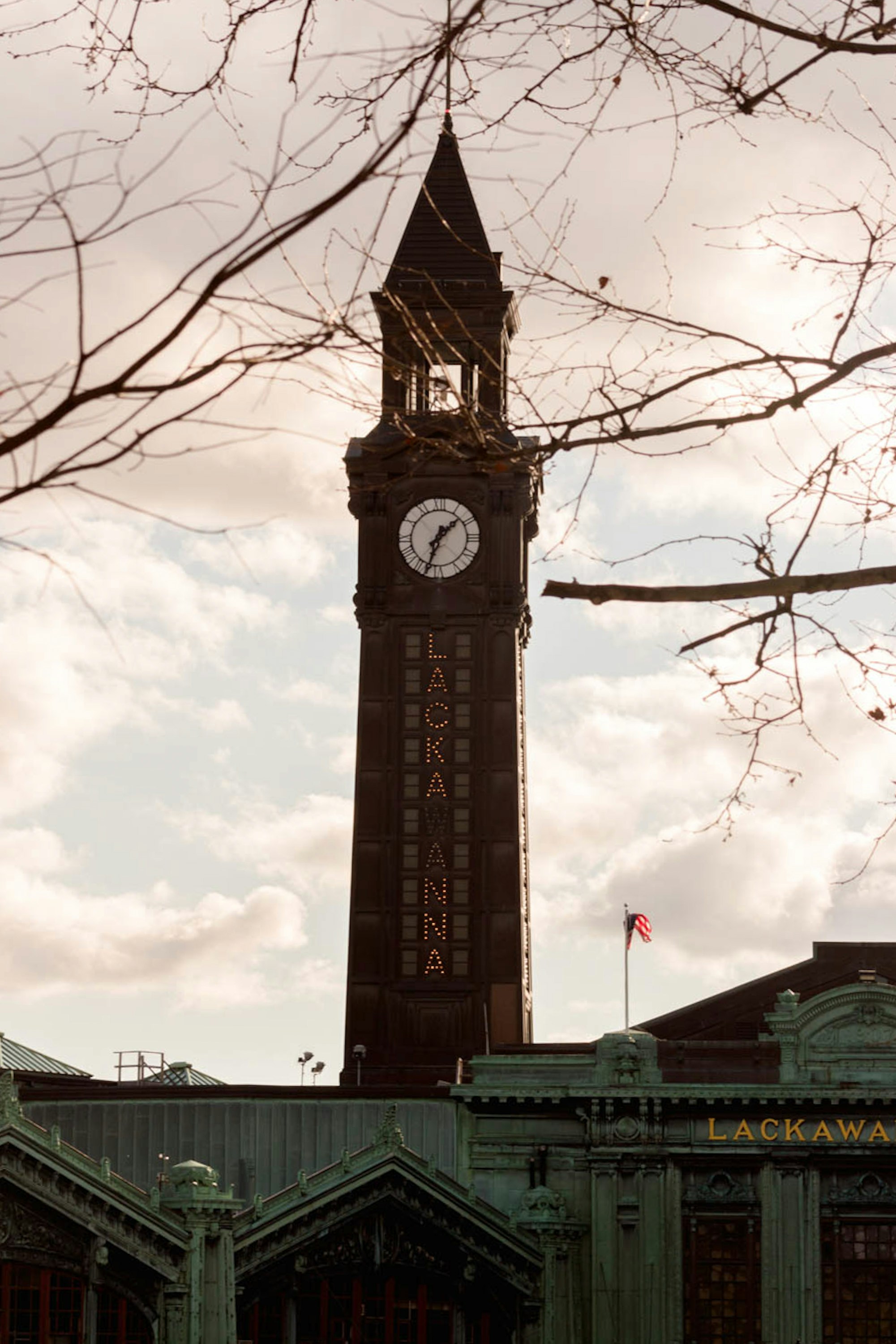 Clock tower with "lackawanna" text, against cloudy sky.