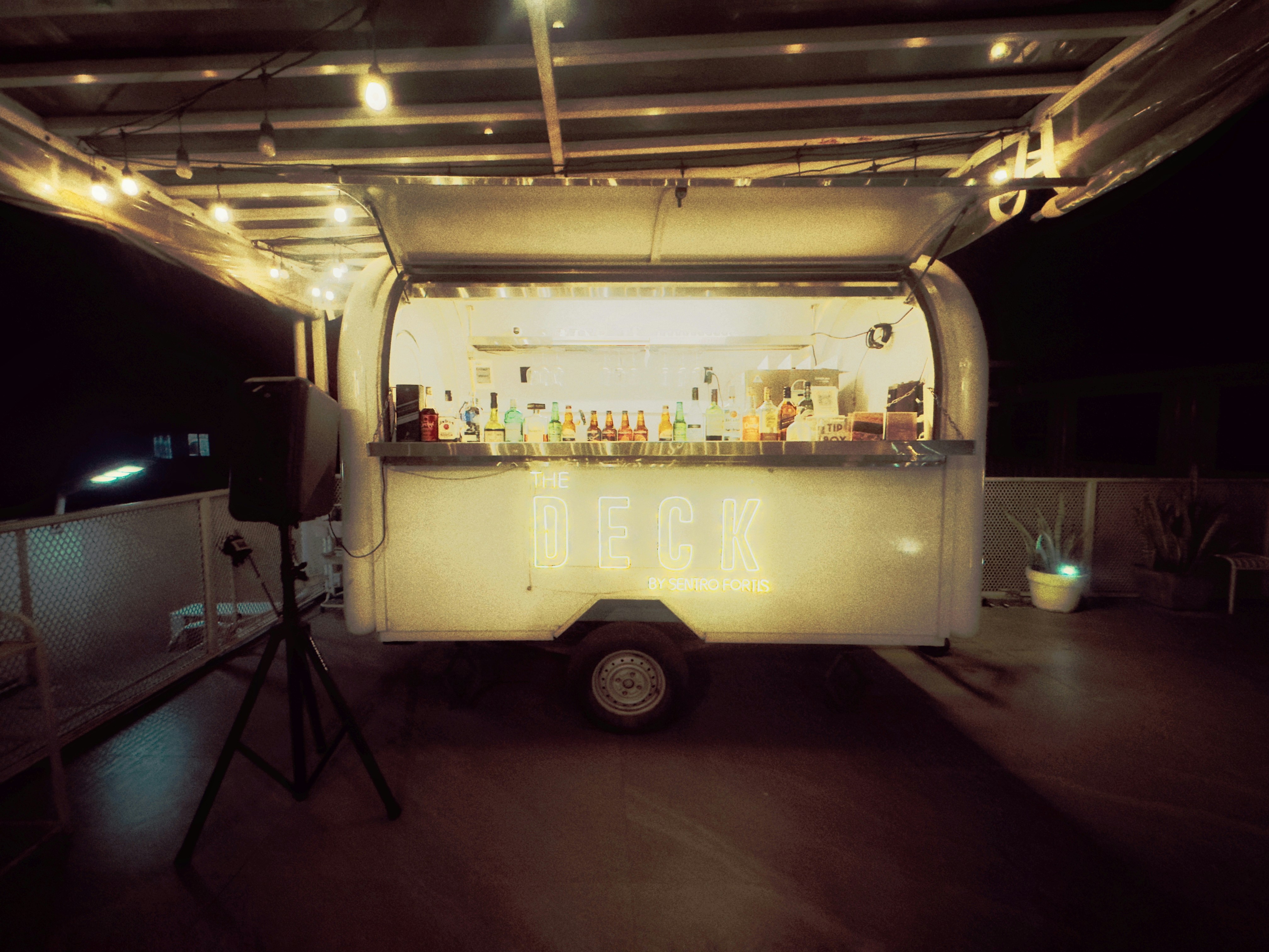 The deck | A mobile bar setup with string lights at night