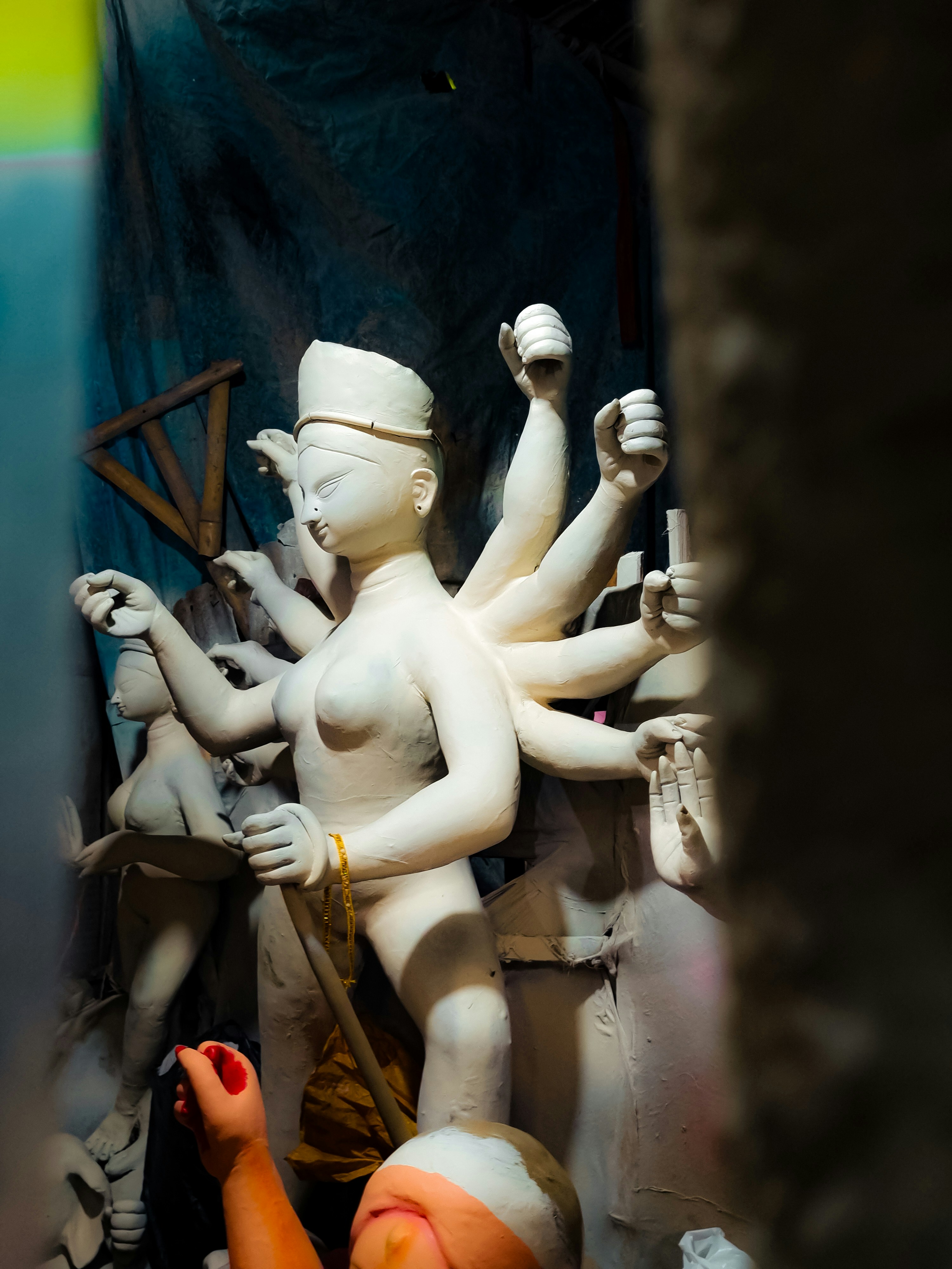 Unfinished white sculpture of a multi-armed deity