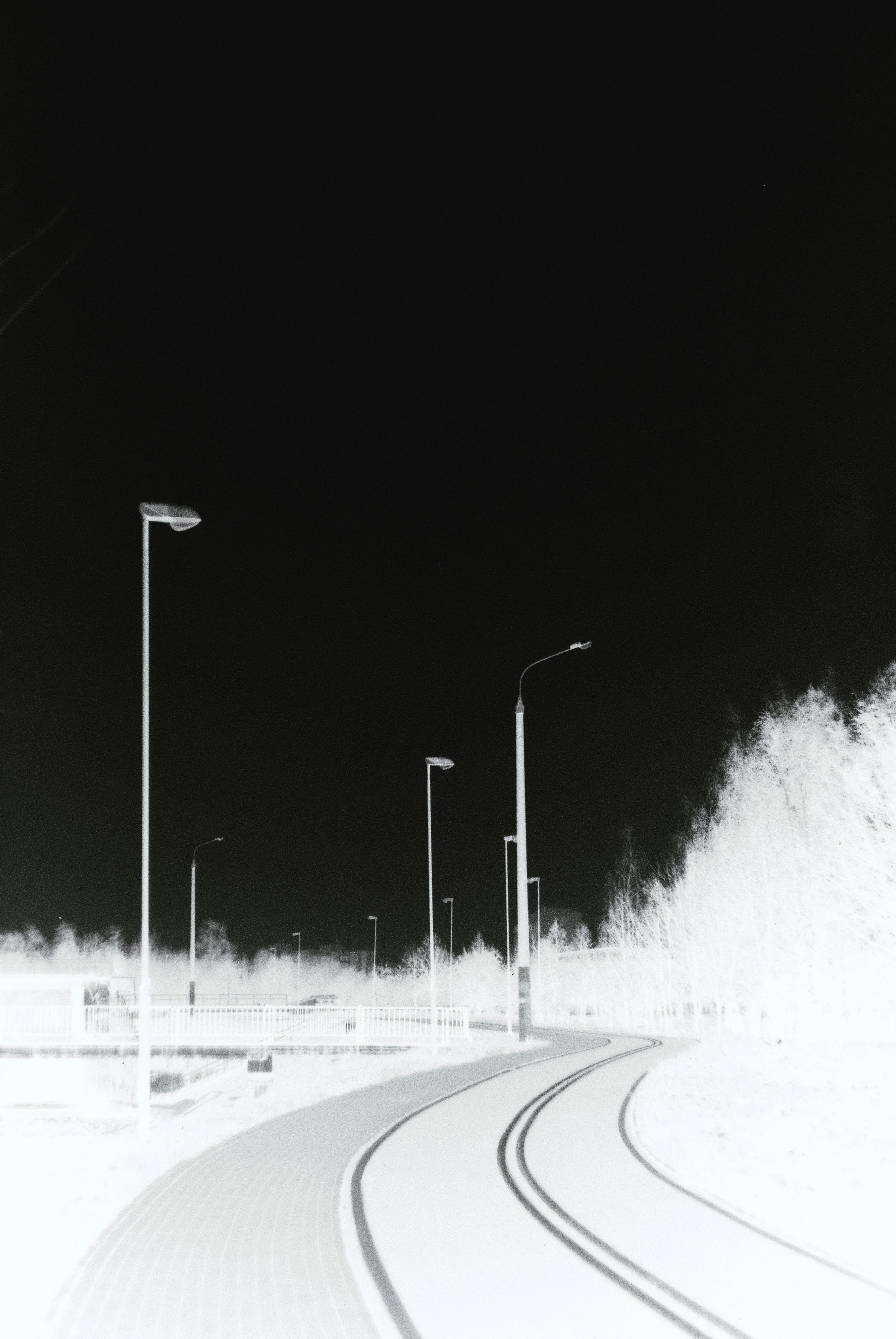 Streetlights line a winding path under a dark sky.
