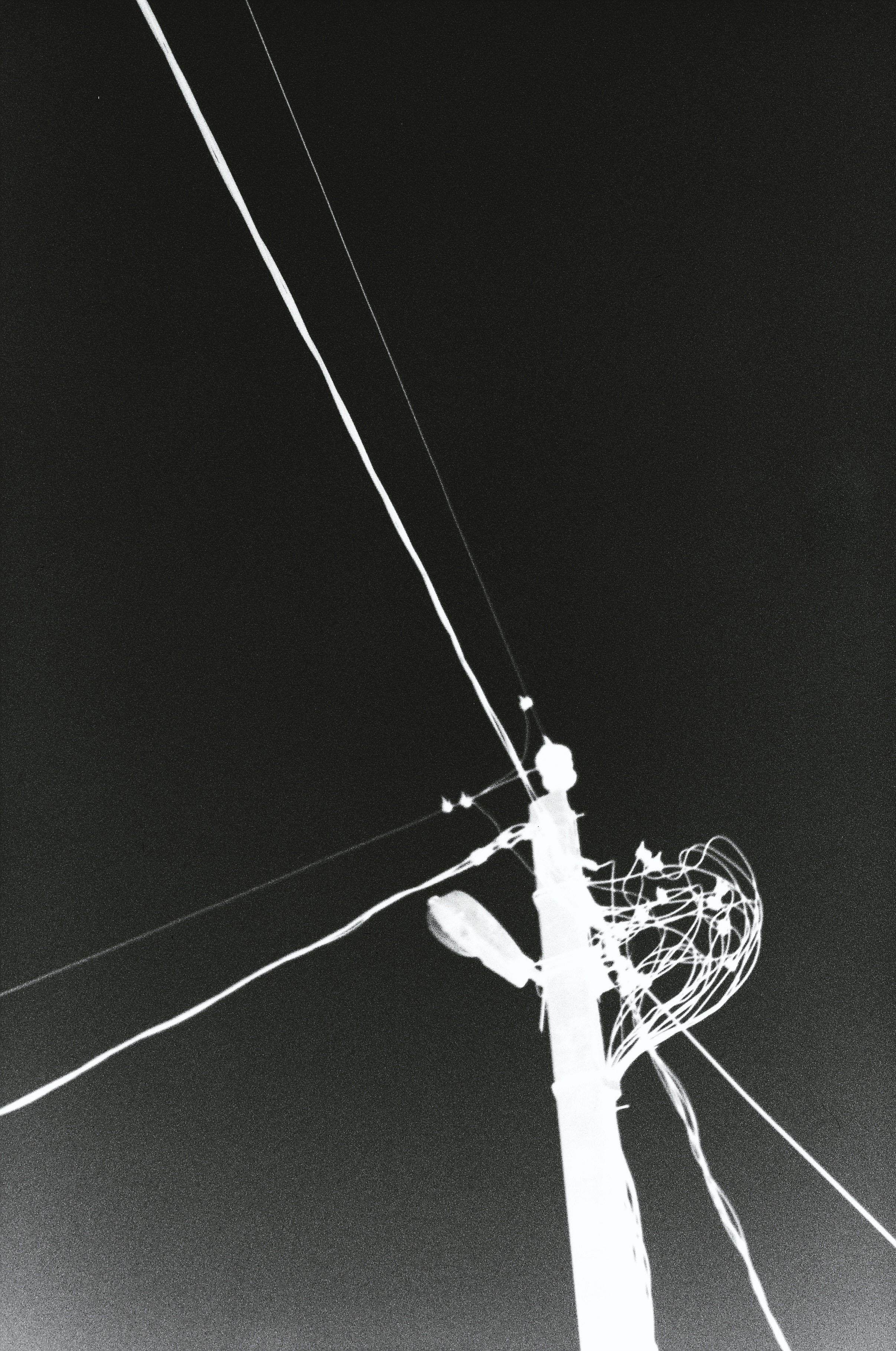 Telephone pole with wires against a dark sky