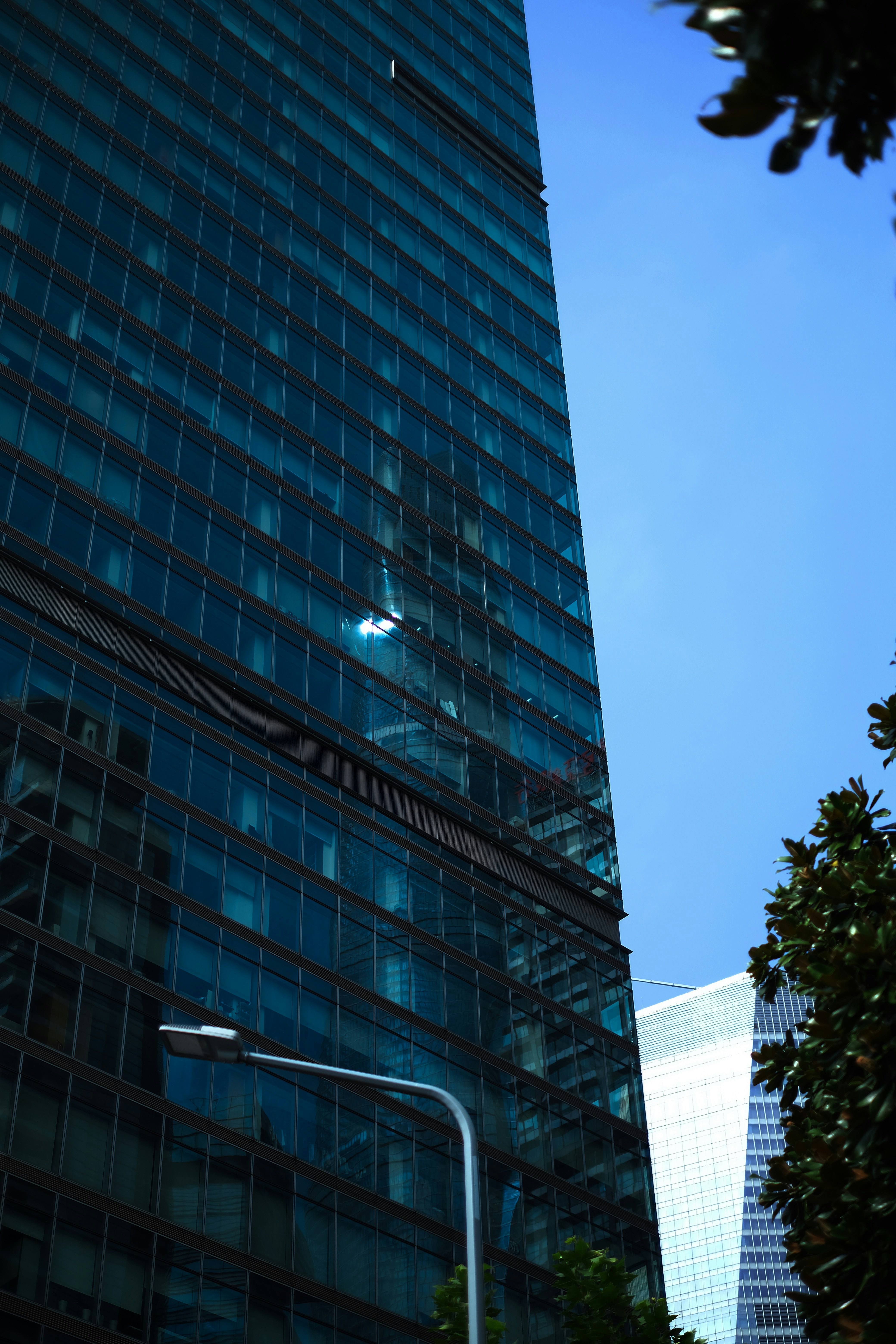 Modern glass skyscraper against a clear blue sky.