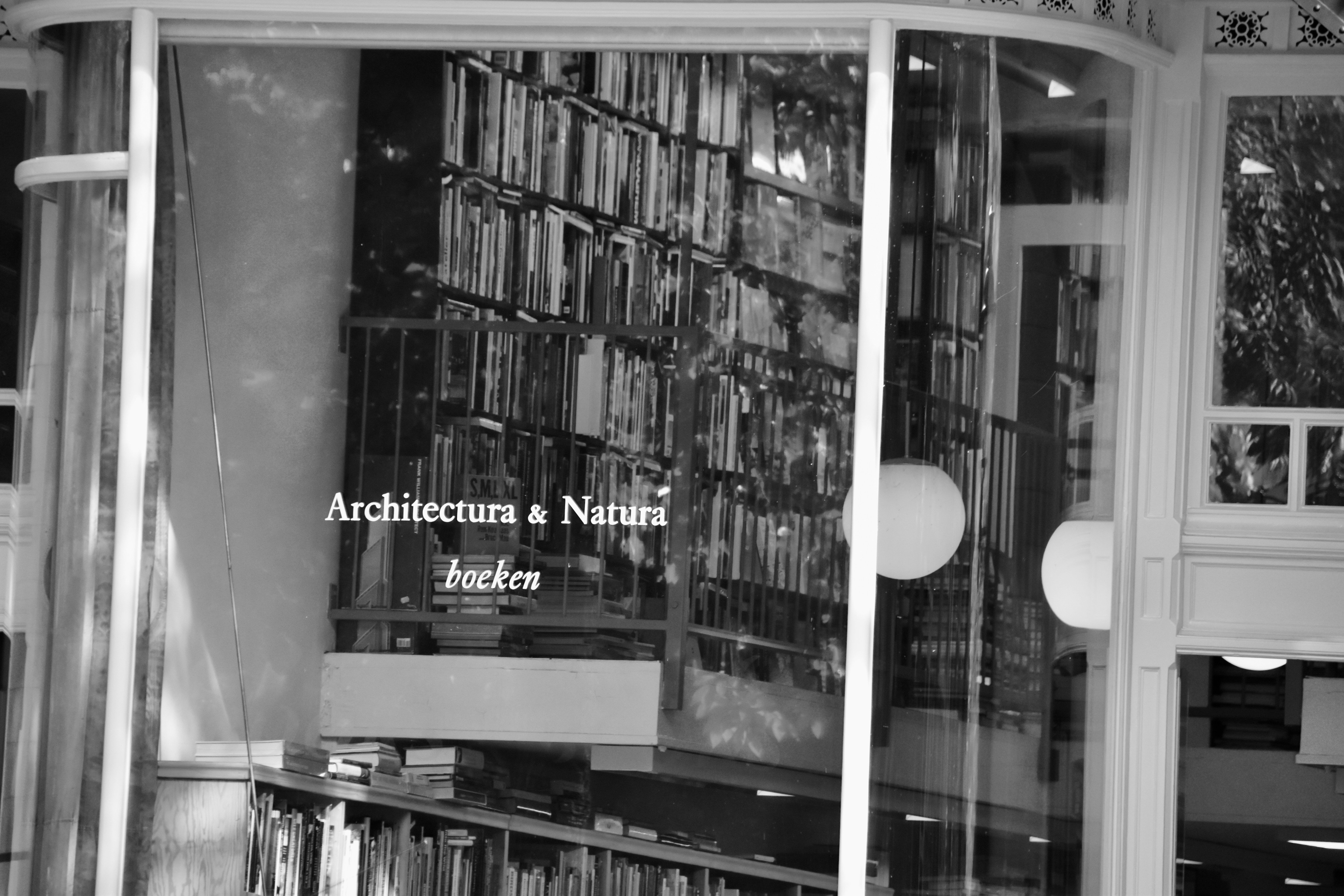 Bookshelves reflected in a glass storefront window.