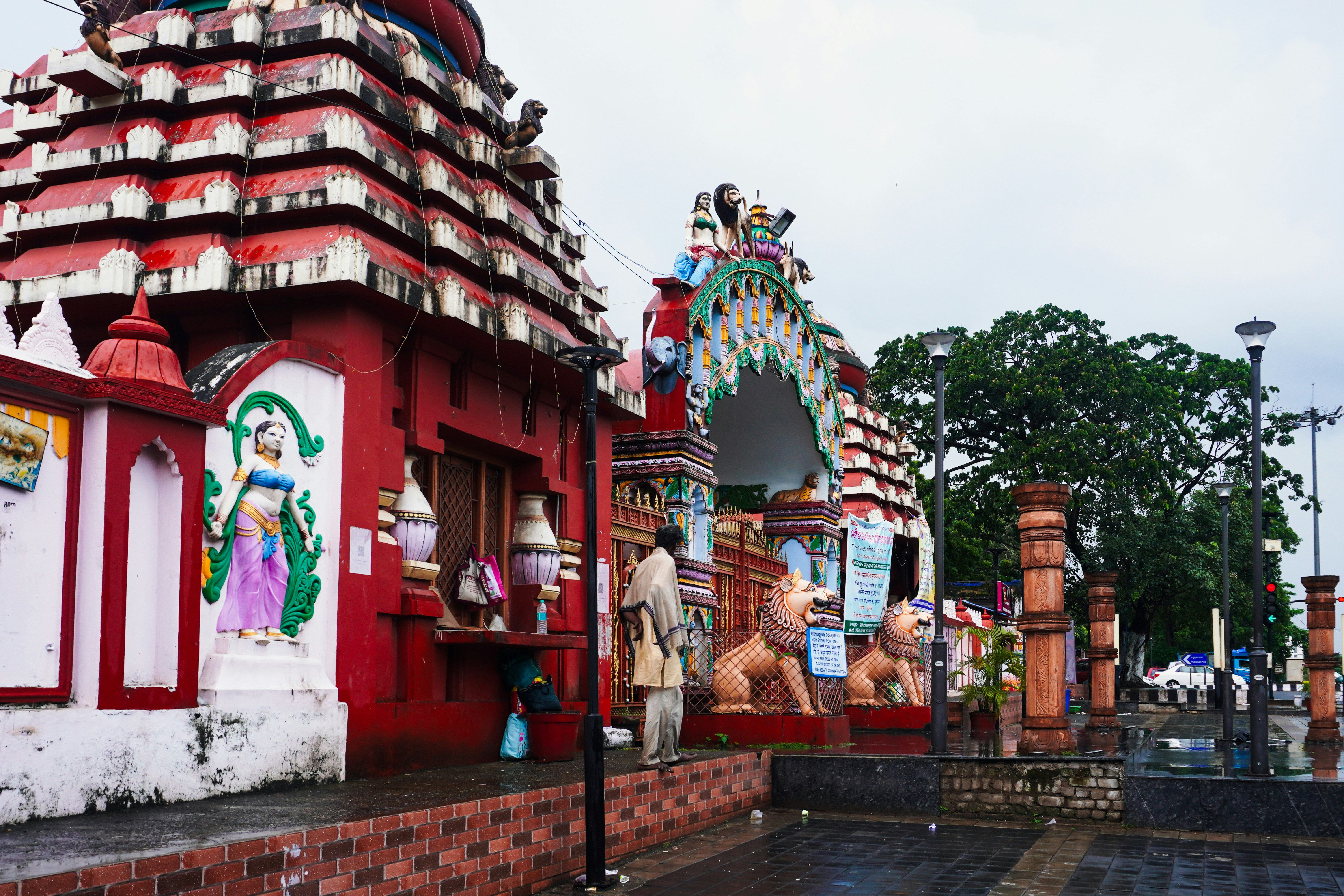 Vivid Temple Gateways: Colorful Carvings Framed by a Rainy Promenade