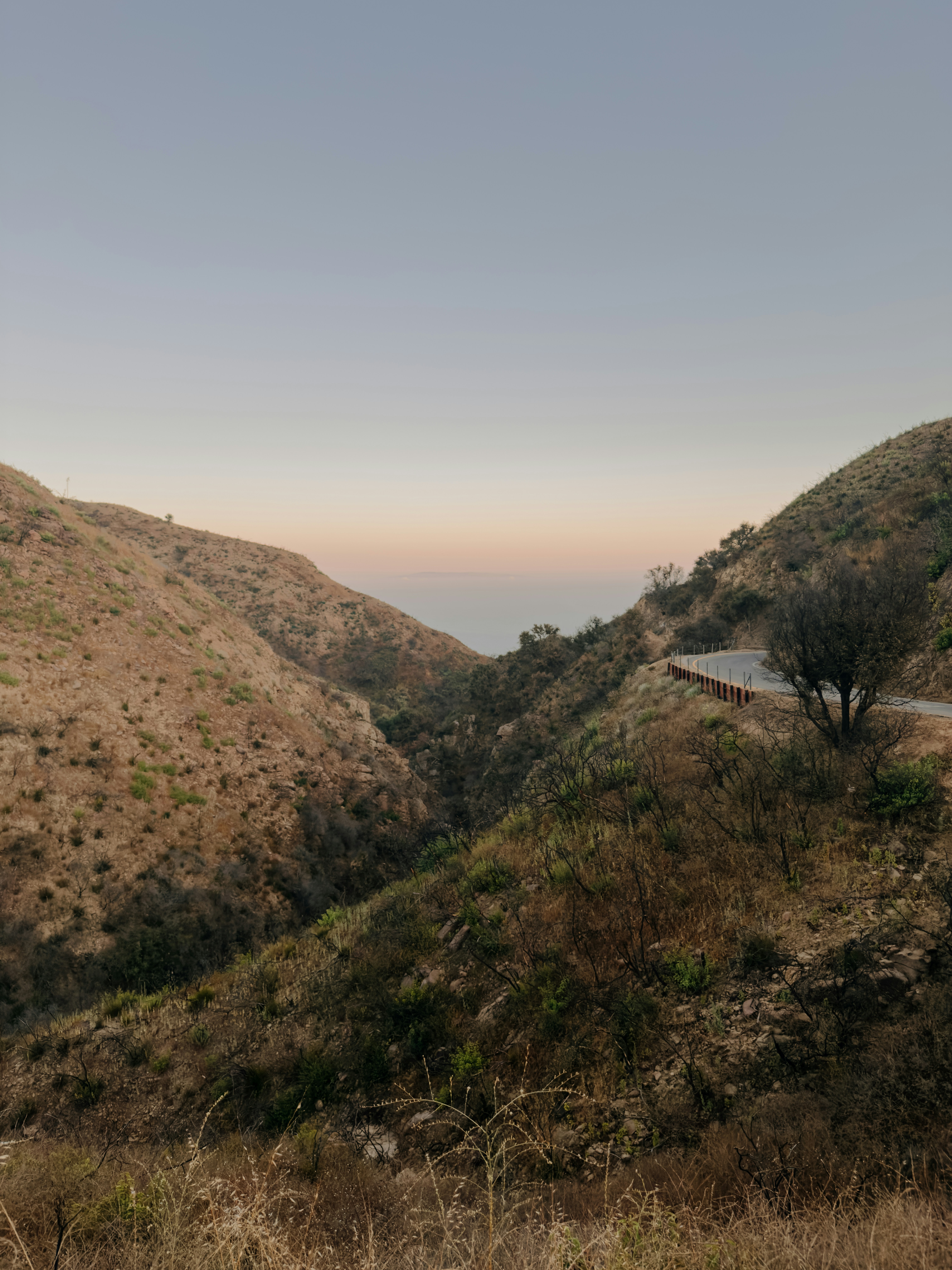 A winding road through a dry, hilly landscape.