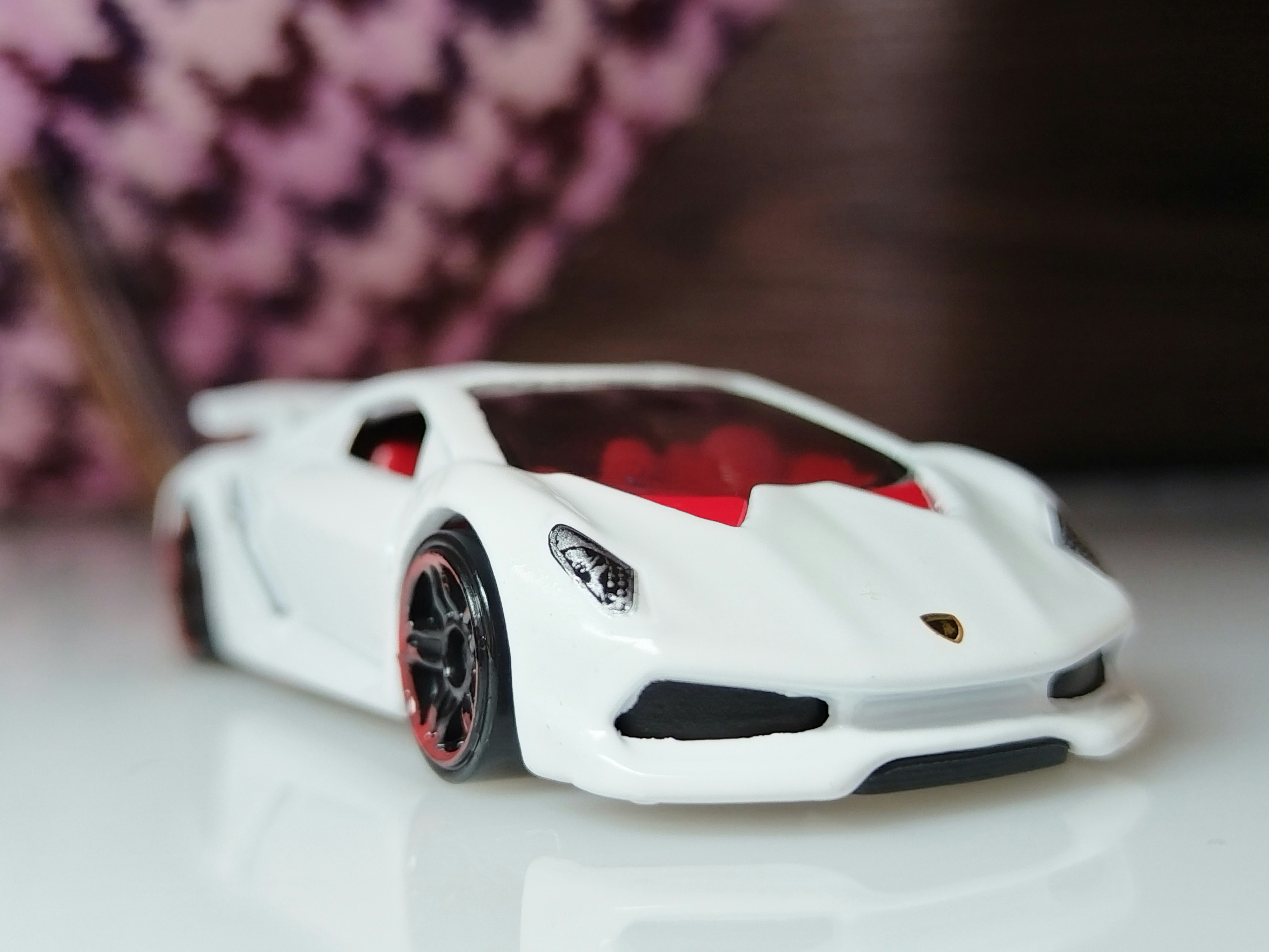 Hotwheels Lamborghini Sesto Elemento | A white toy sports car with red interior.