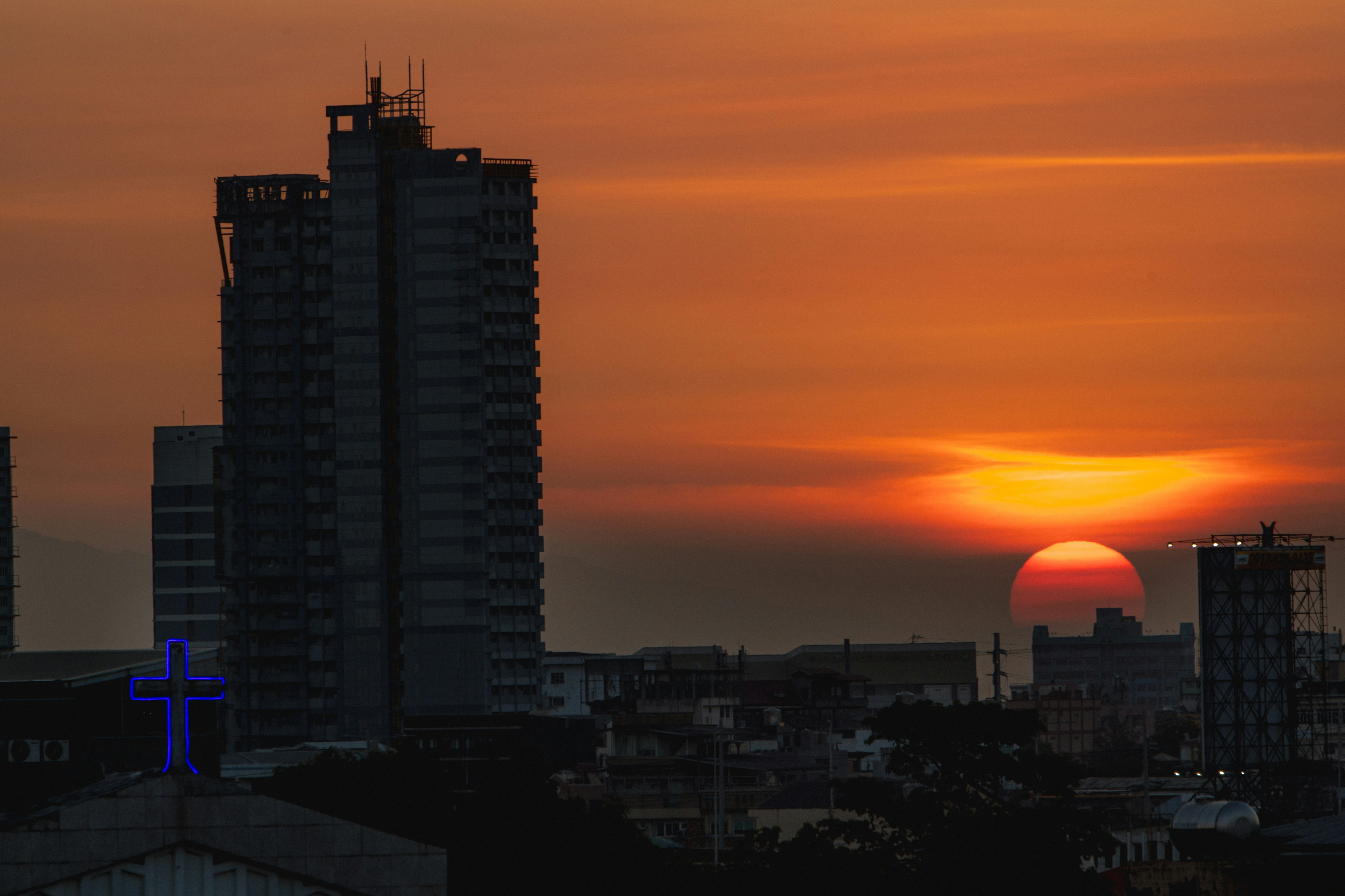 Sunset over a city skyline with tall buildings.