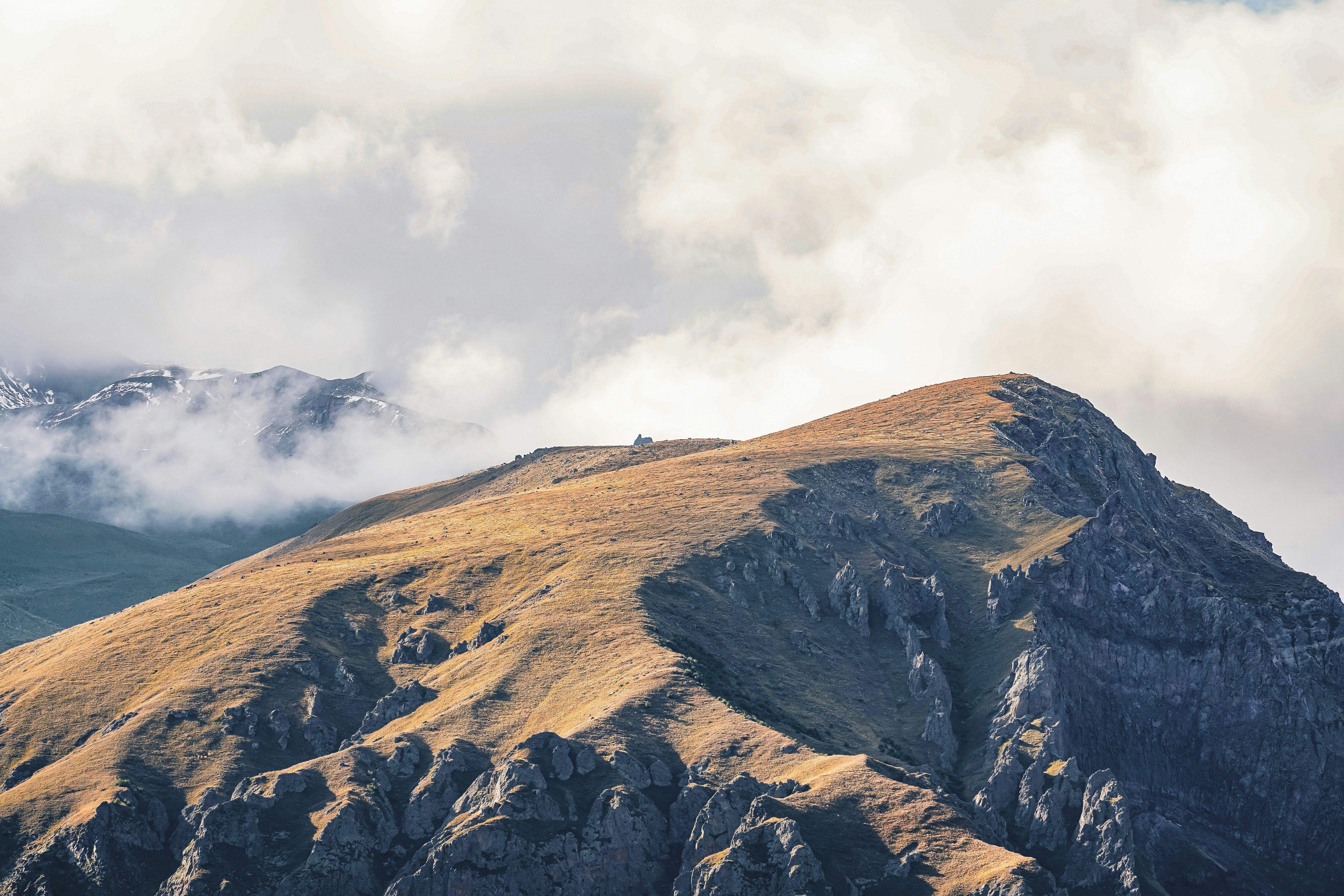 Kaukasus view | Golden mountain peak under cloudy sky