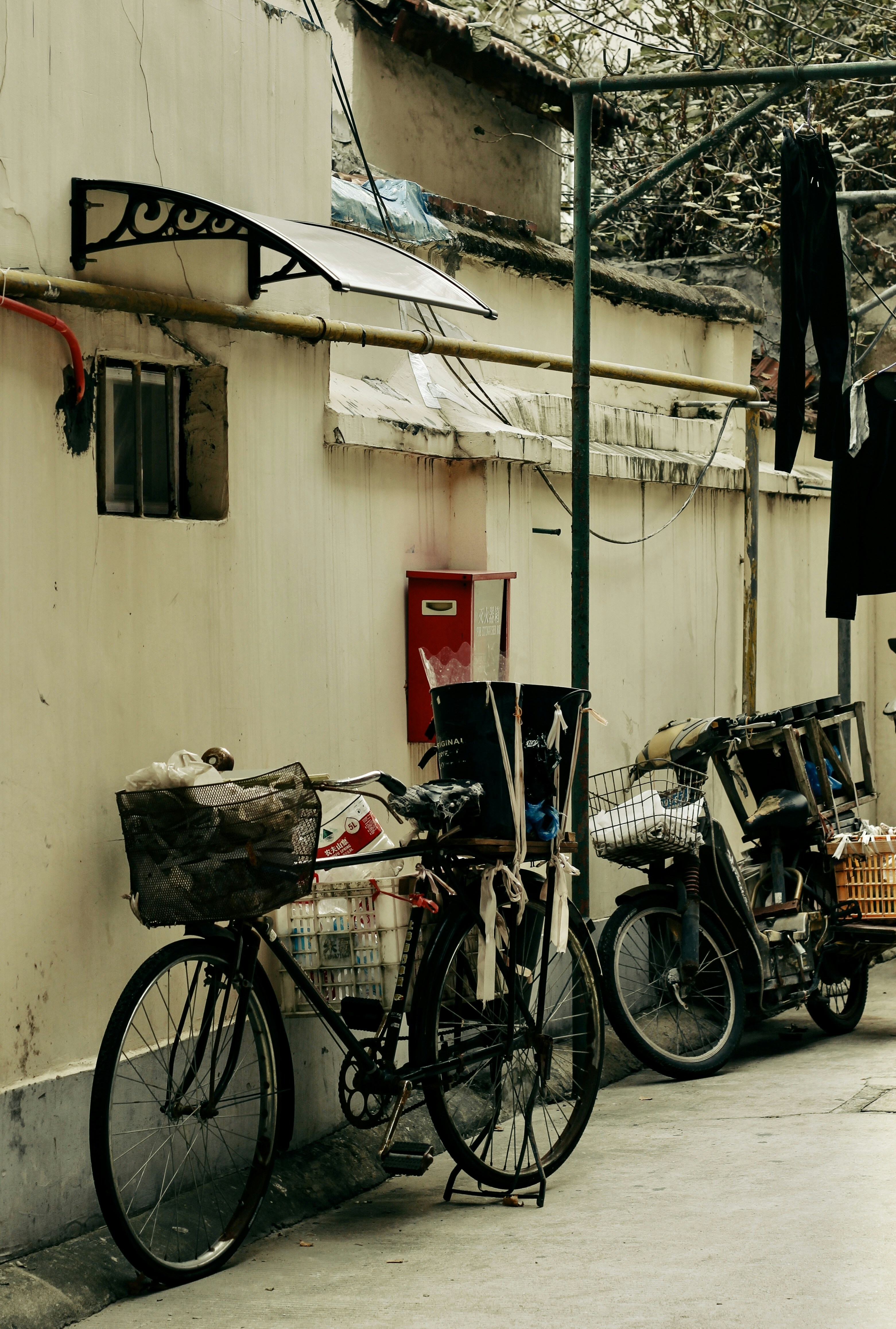 Two bicycles parked against a light-colored wall.