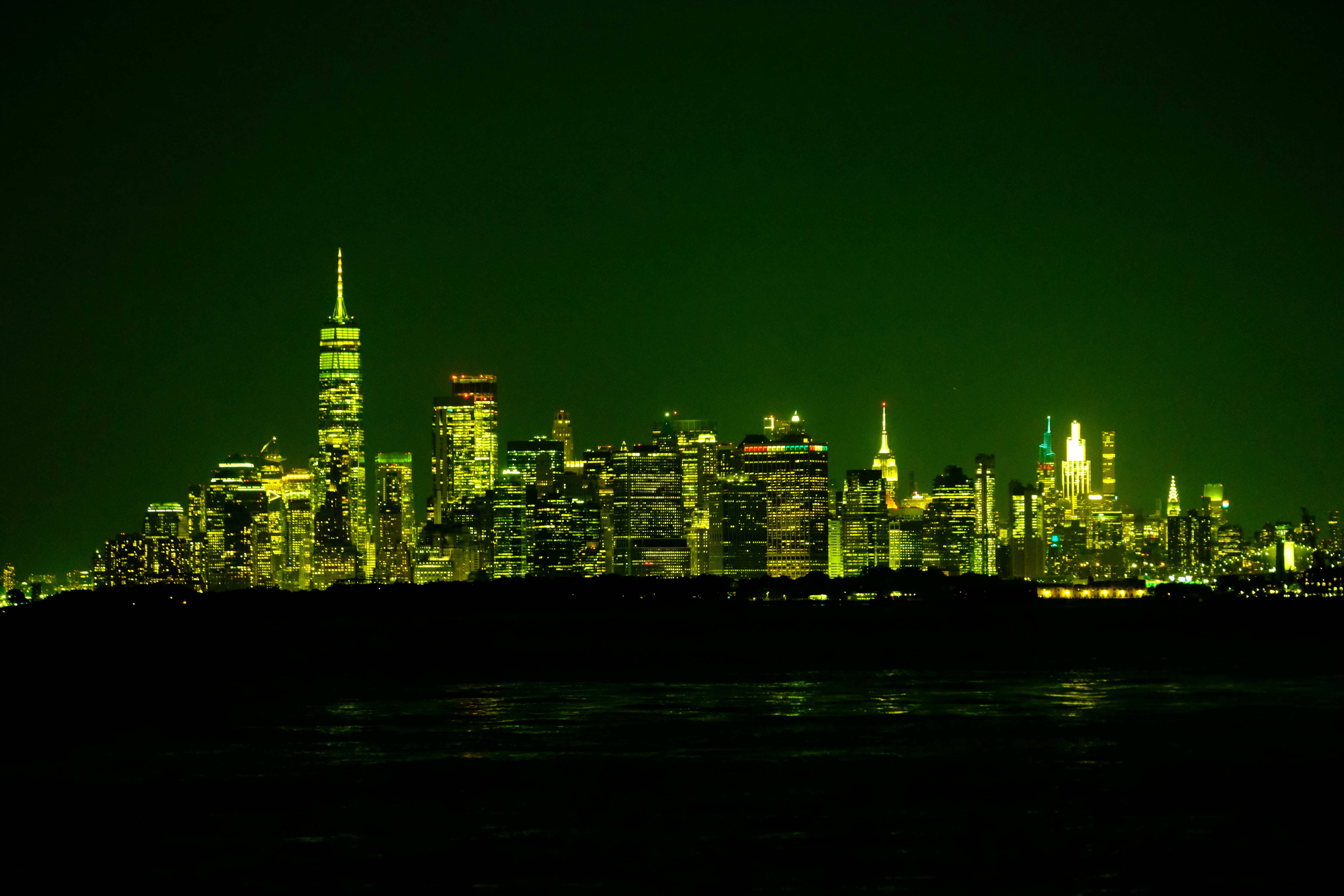 NYC skyline from brooklyn | Brightly lit cityscape skyline at night under green sky