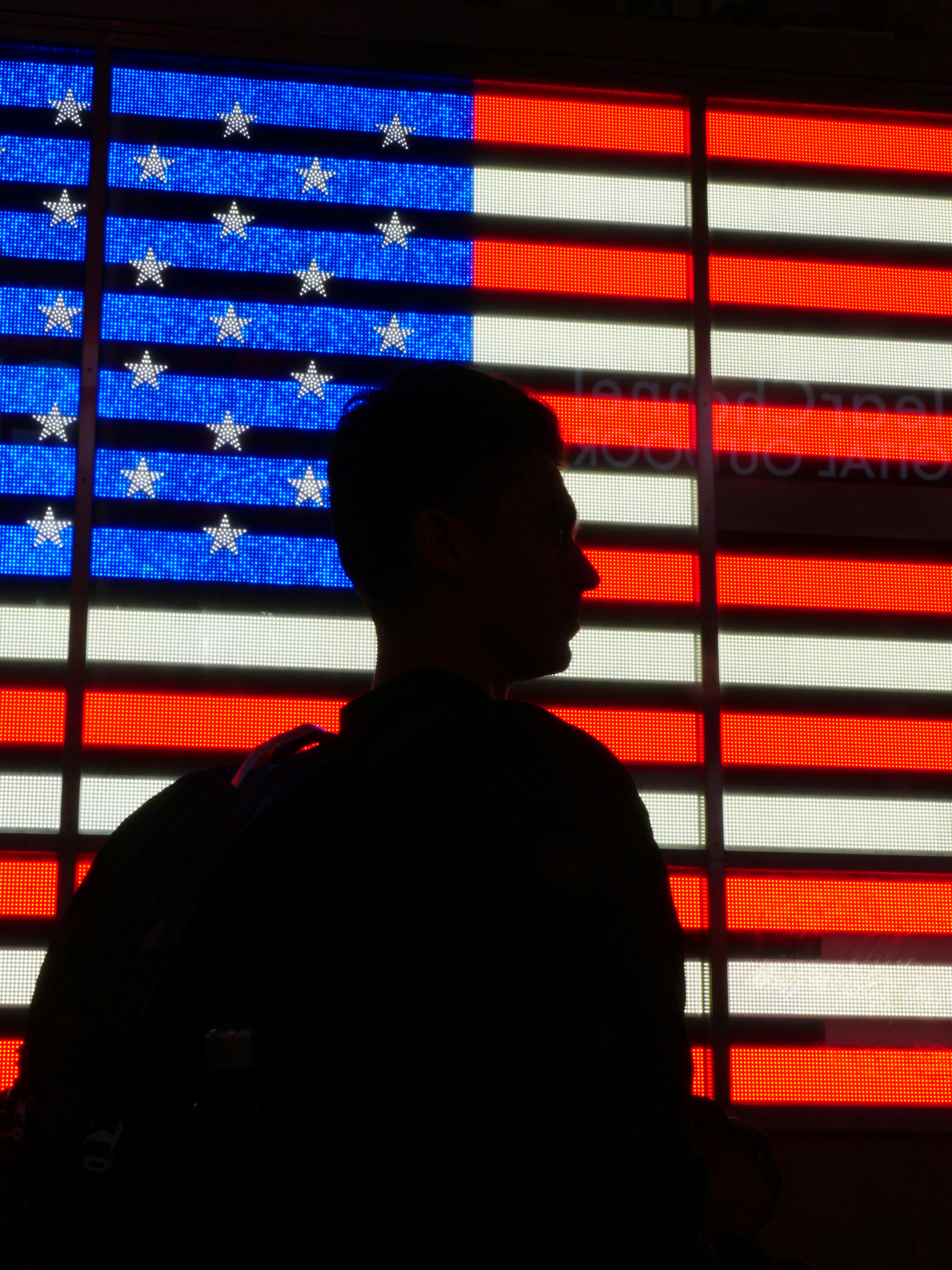 Silhouette of person against illuminated american flag