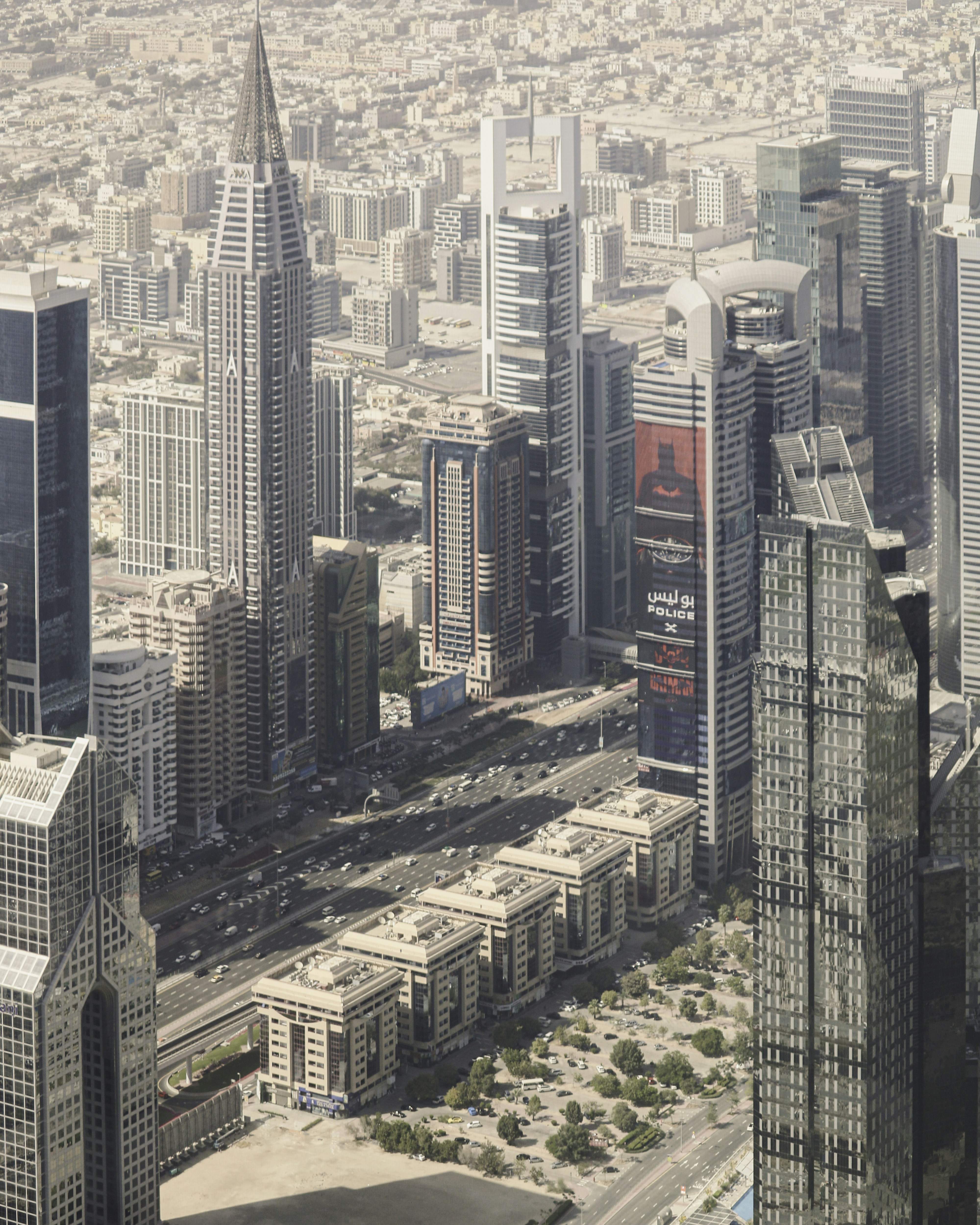 Aerial view of a bustling urban landscape showcasing a mix of modern skyscrapers and busy roadways in a vibrant city. The architectural diversity highlights the dynamic nature of urban development.