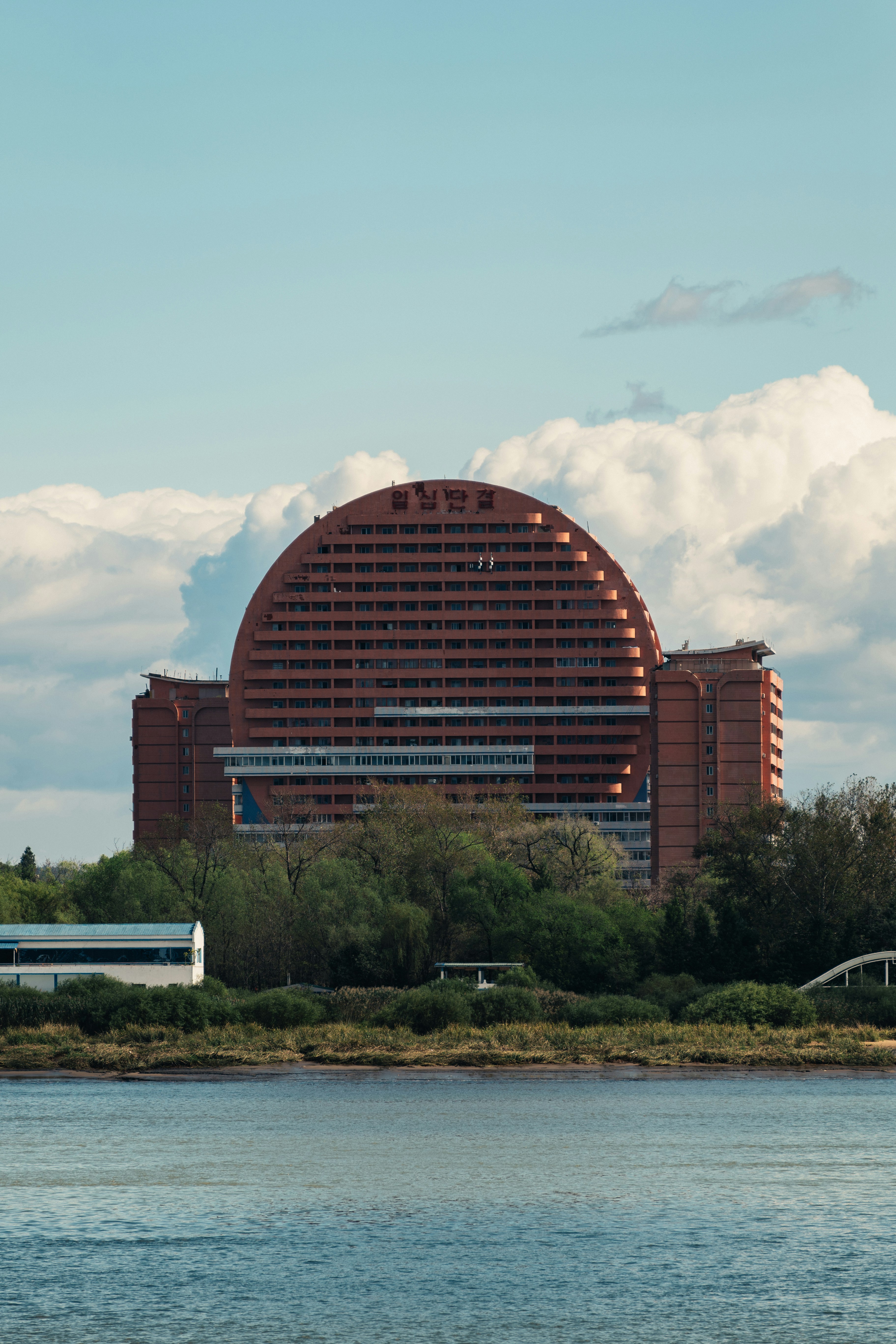 Riverside Ring: A Red Brick Circular Landmark Reaching Toward the Sky