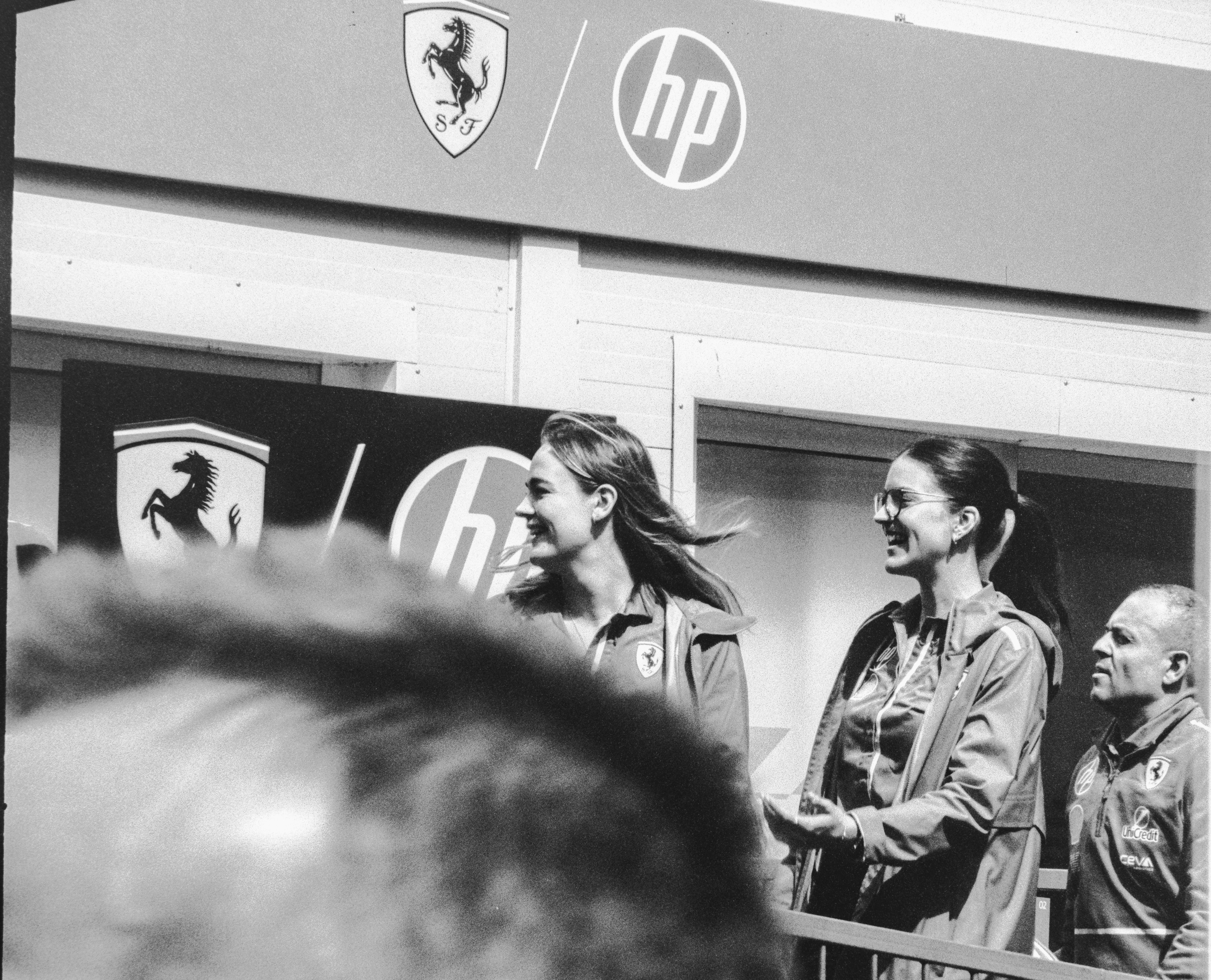 Two smiling women and a man at an event.