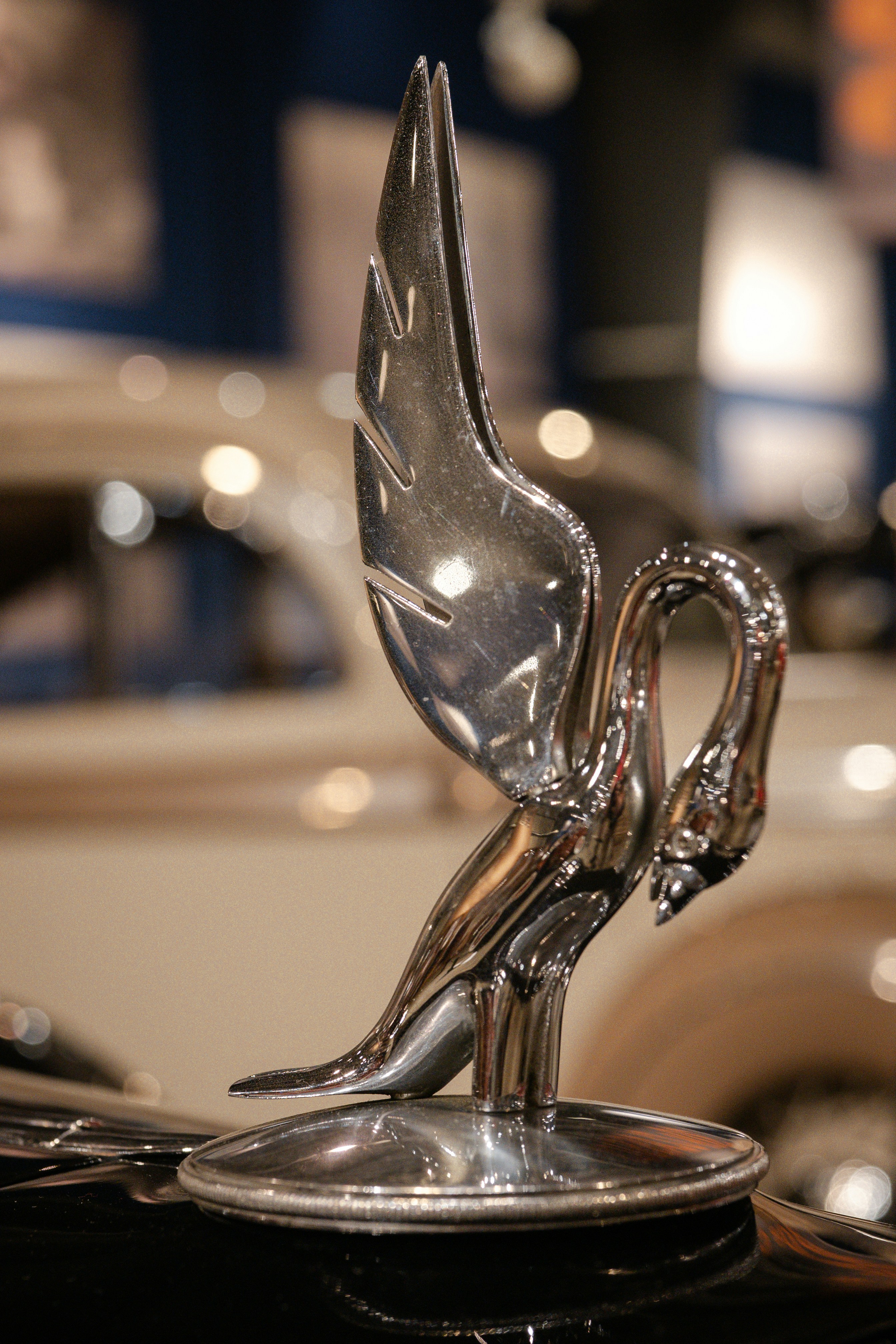 Chrome Winged Hood Ornament: Quiet Radiance on a Vintage Car