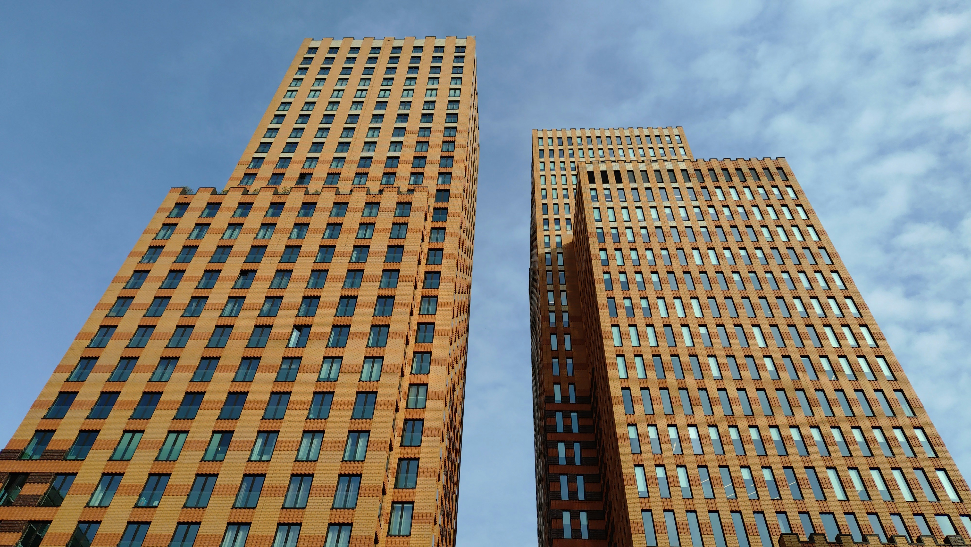 Amsterdam Symphony | Two modern terracotta skyscrapers against blue sky