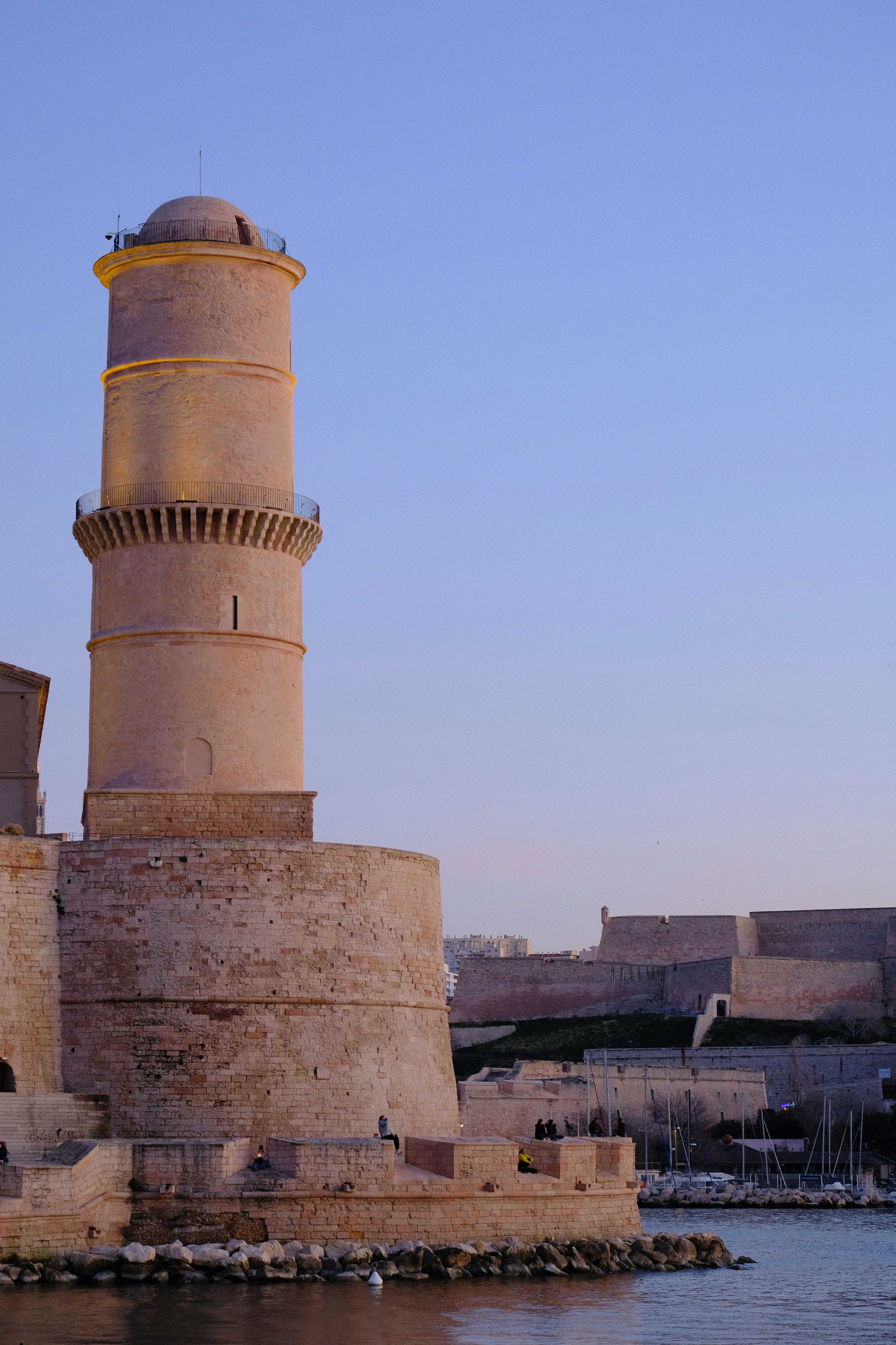 Stone lighthouse and fortress by the water.