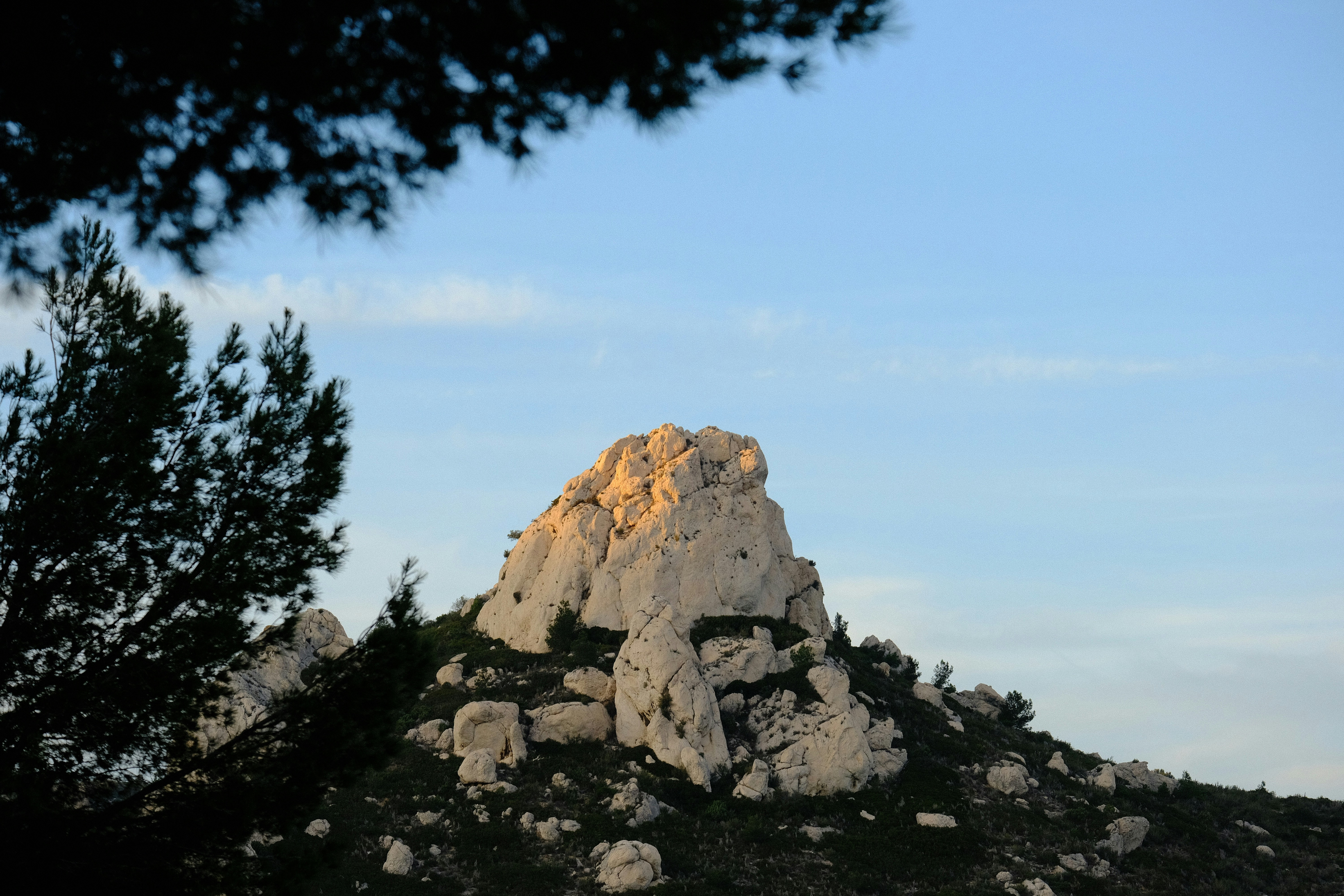 Rocky outcrop bathed in soft sunlight against blue sky