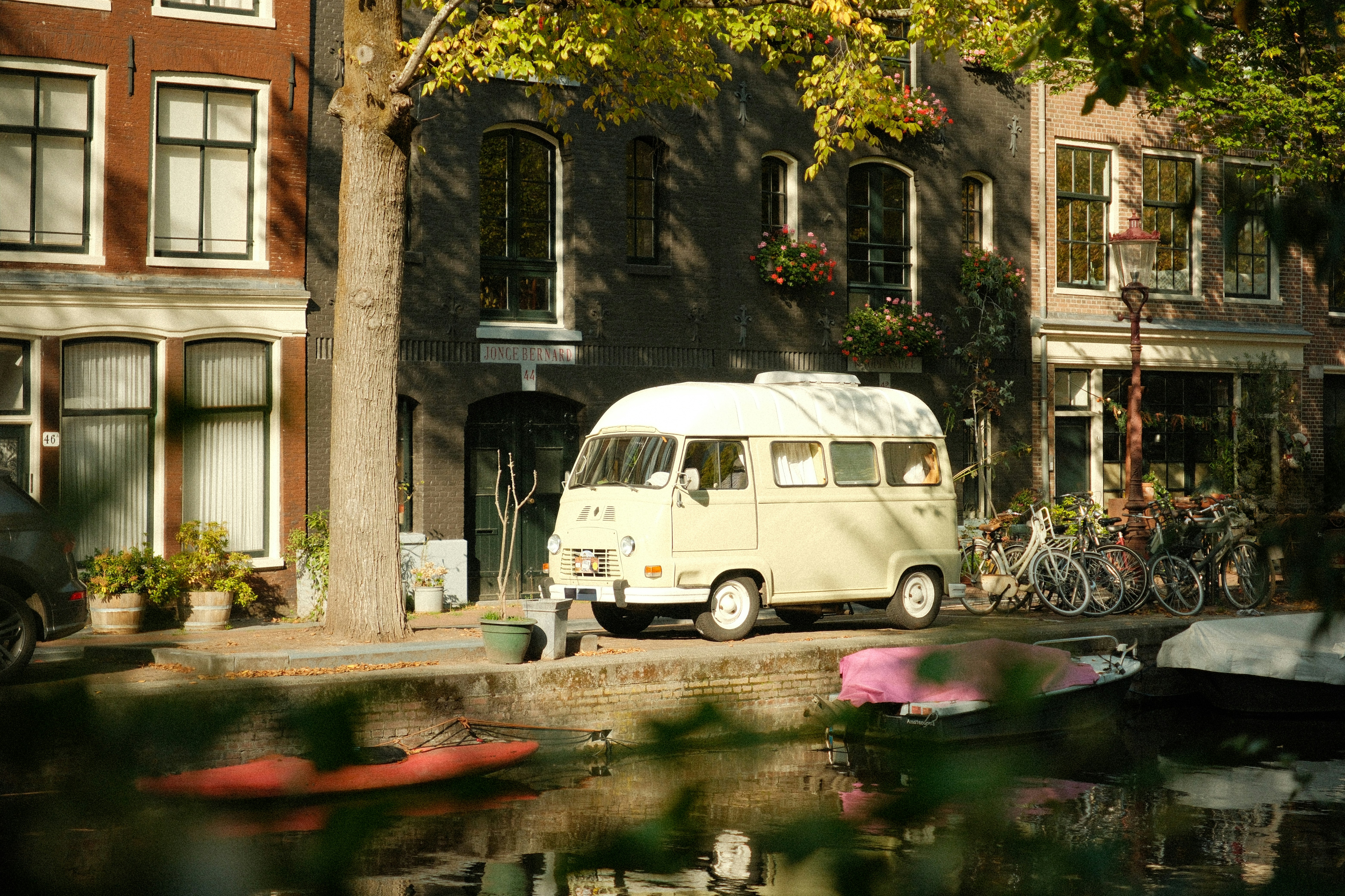 Vintage camper van parked by canal in city