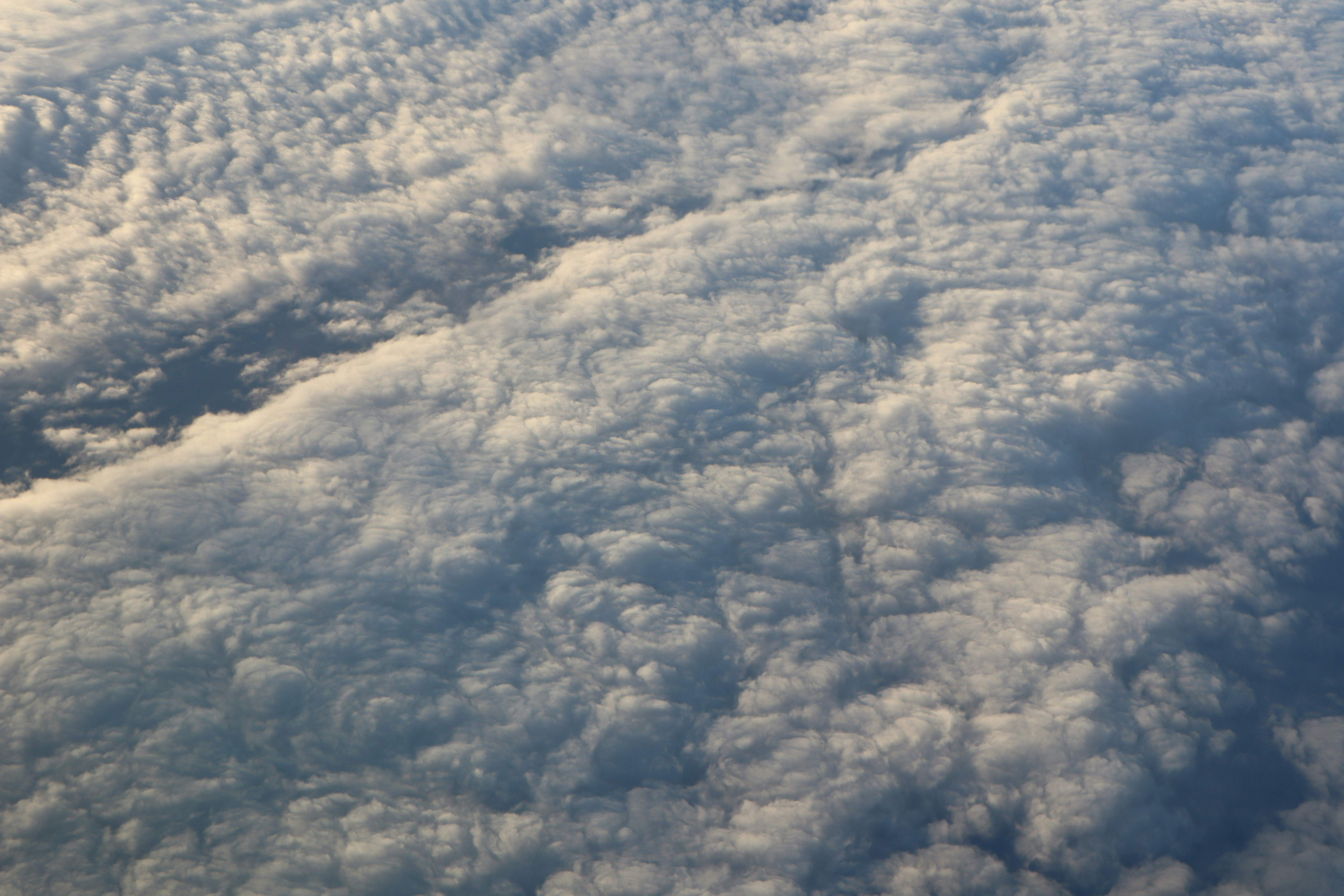 Fluffy white clouds seen from above at sunset.