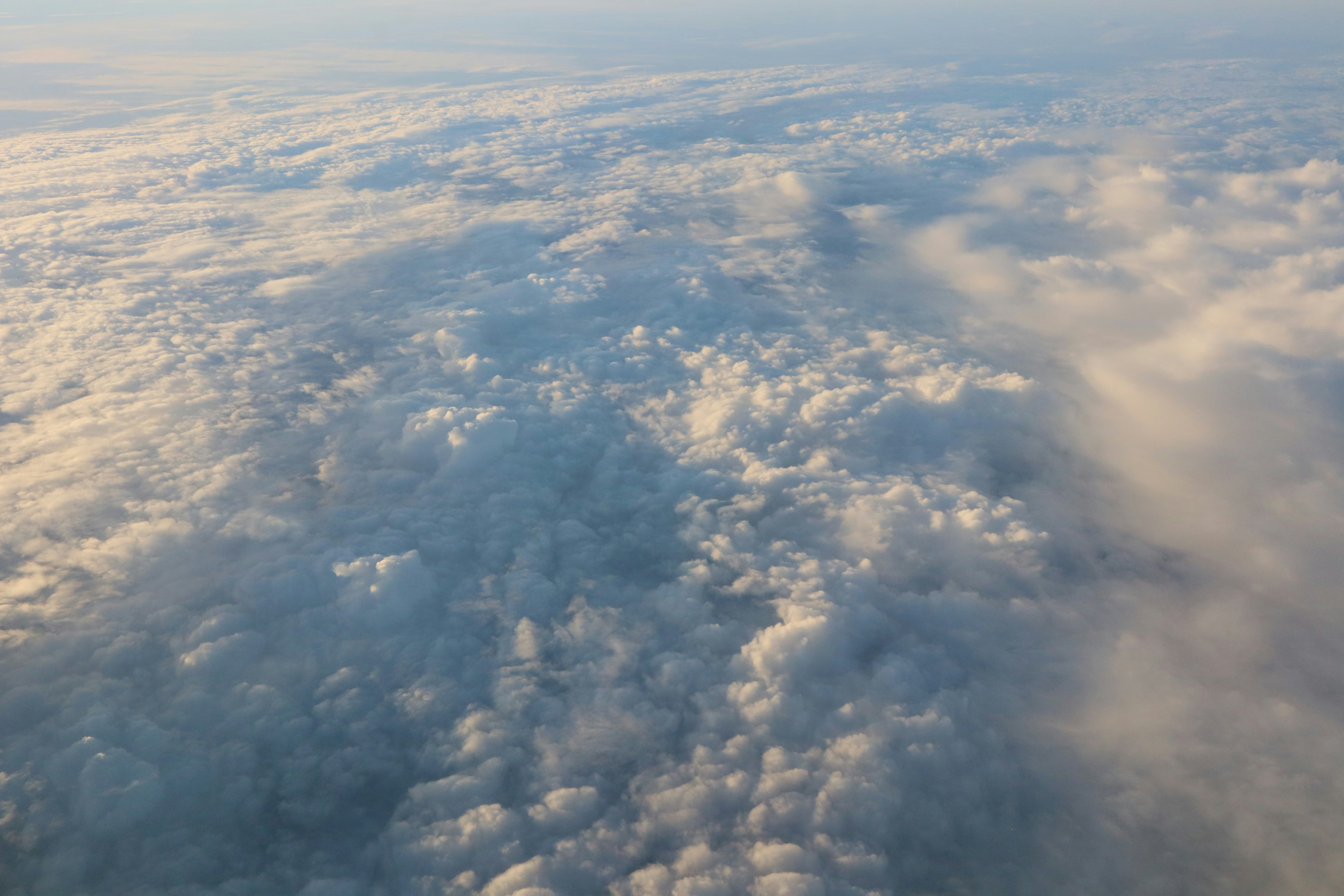 Fluffy white clouds seen from above during daytime.