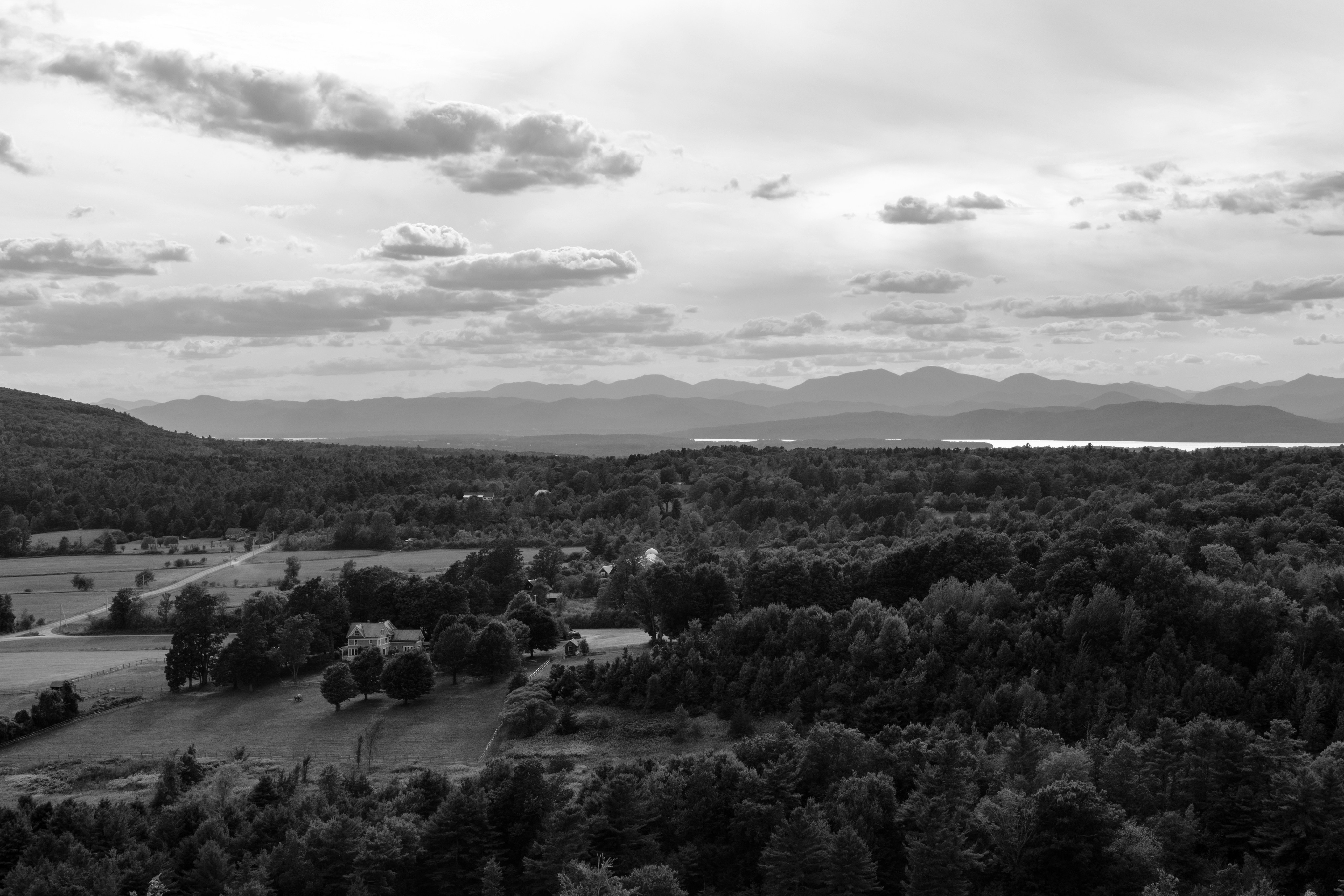 Rolling hills and distant mountains under a cloudy sky