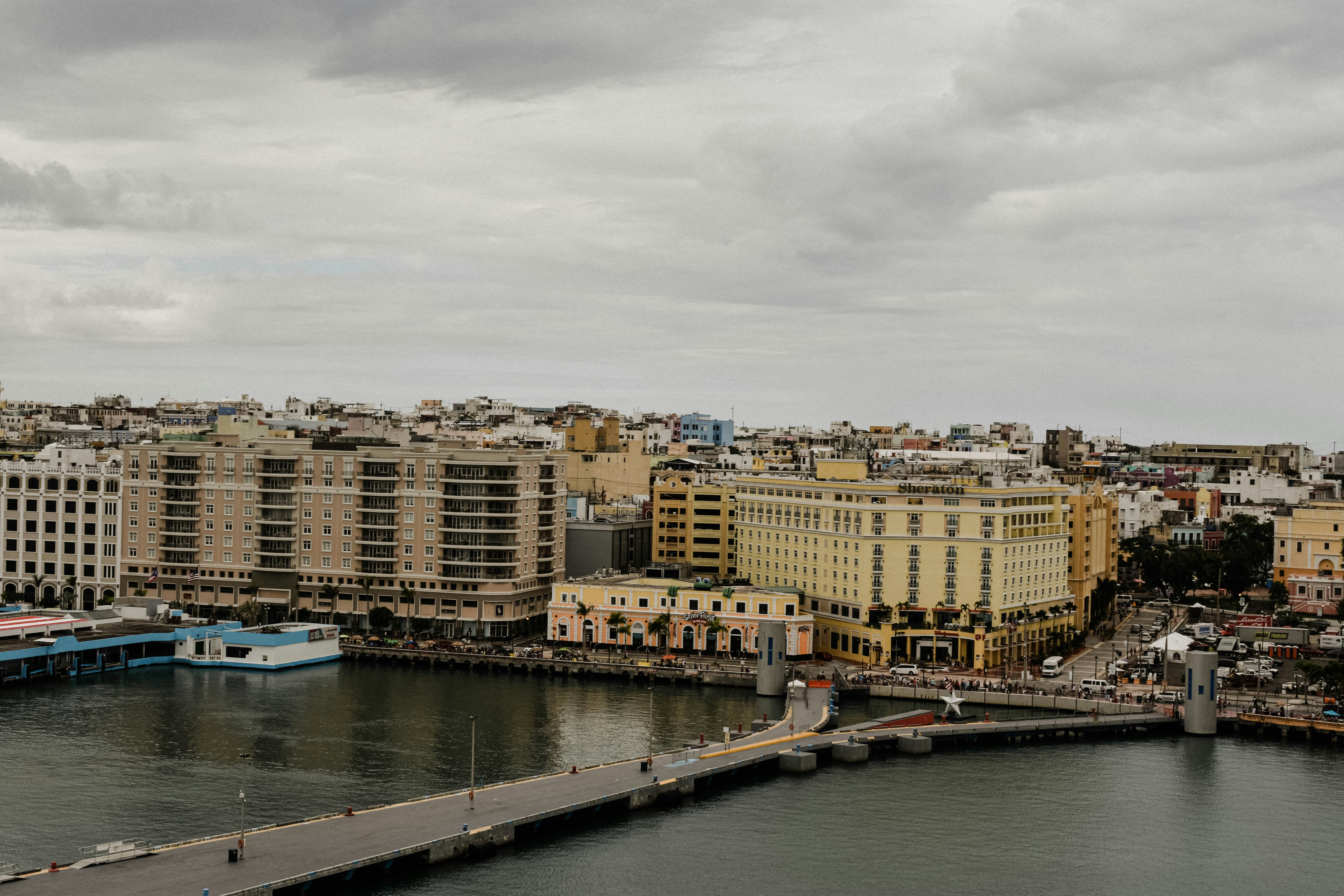 City buildings along a river with a bridge.