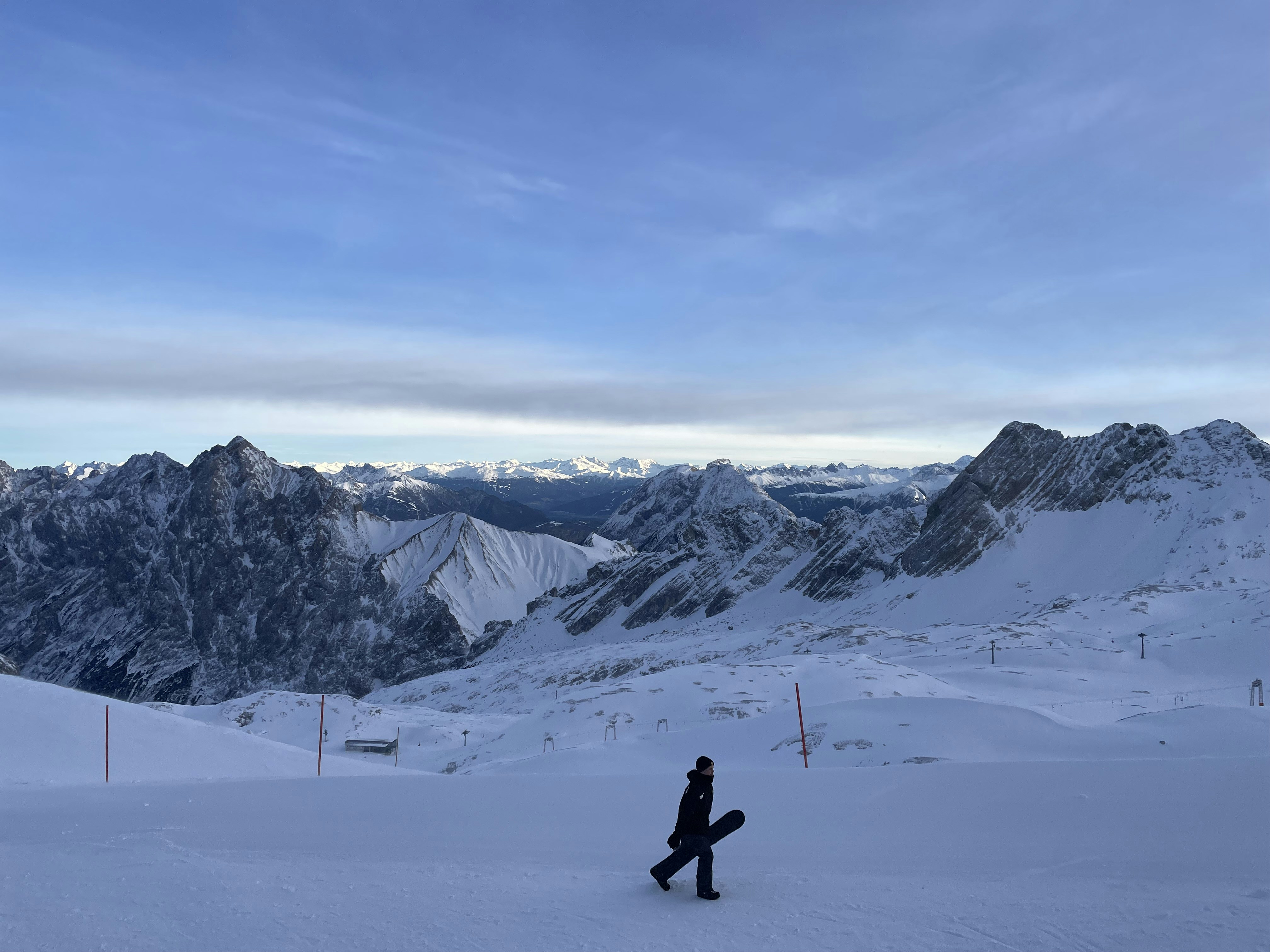 Person walking on snowy mountain with snowboard