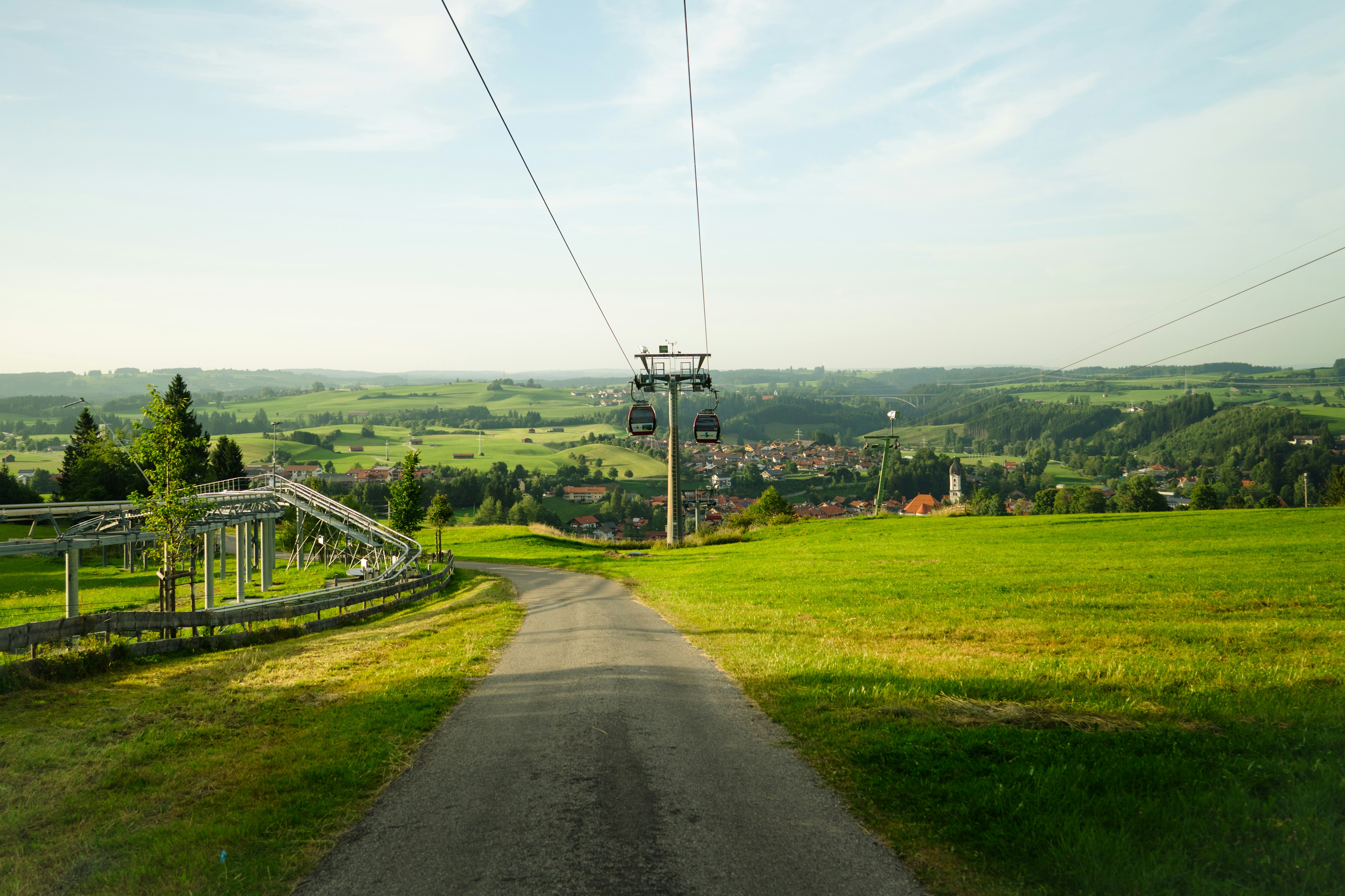 A road leads to a village in a green landscape.
