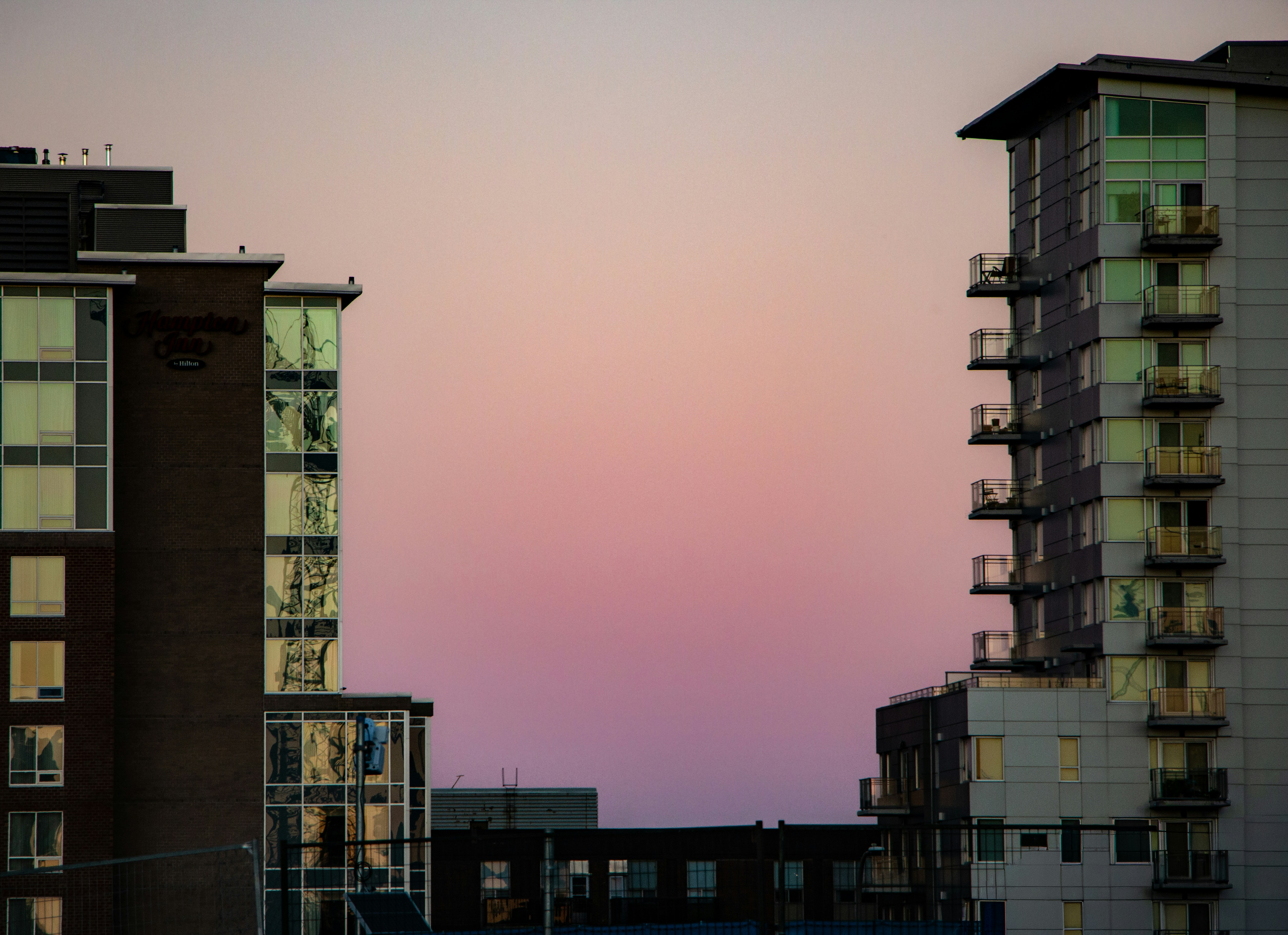 Buildings against a pastel pink and purple sky