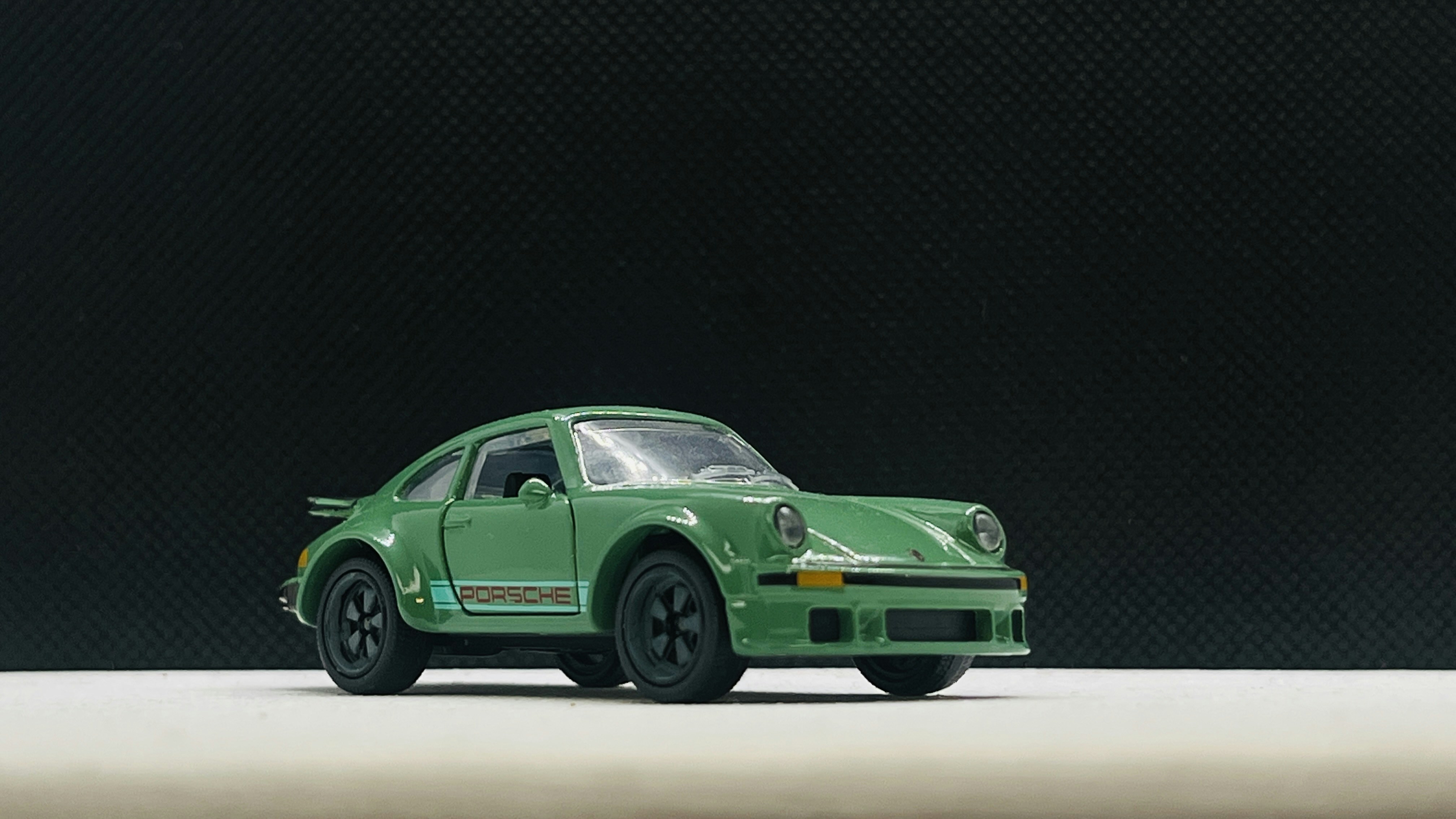 Emerald Mini on a Studio Stage: A Green Scale Car Under Spotlight