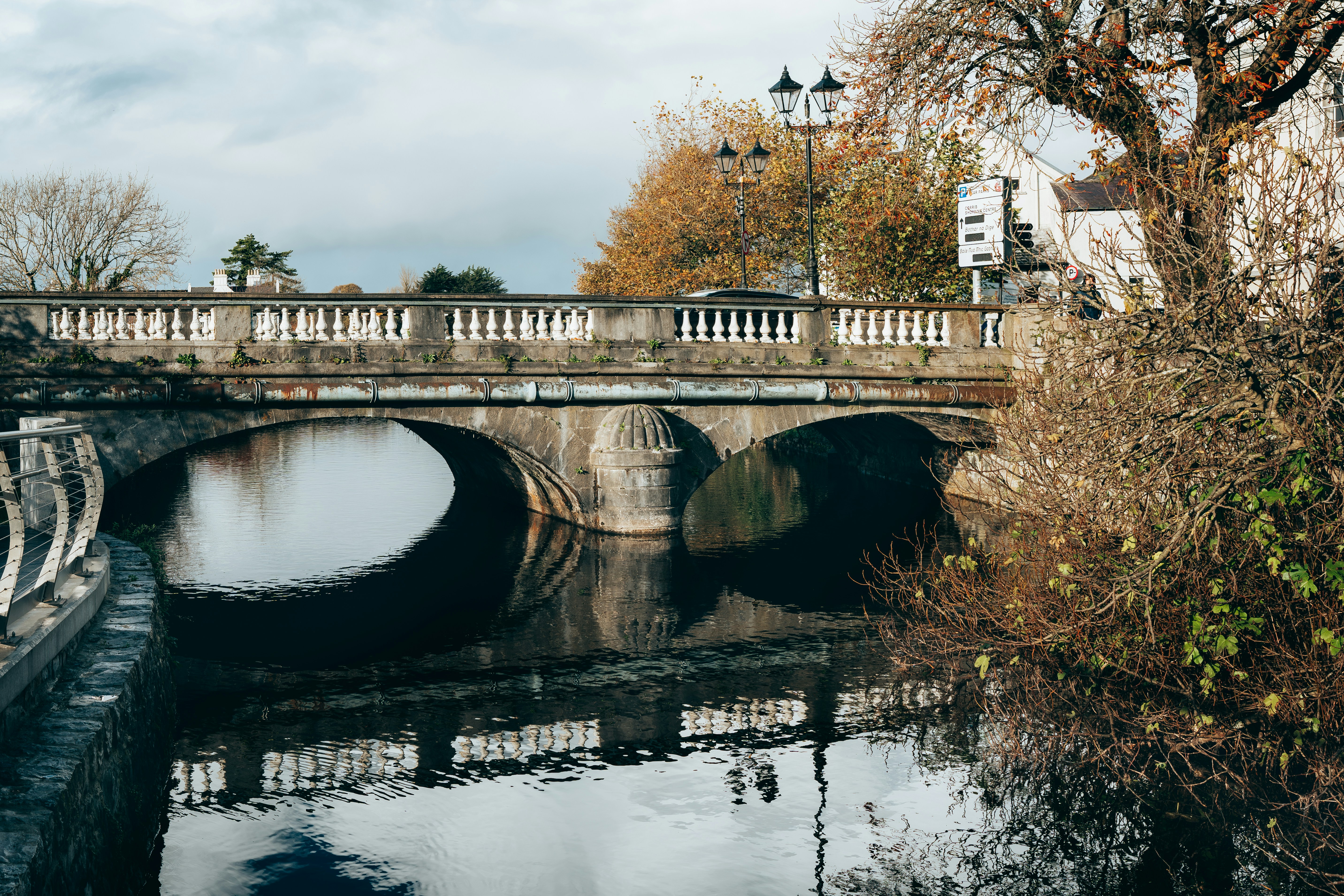 Stone bridge with arches over reflective water