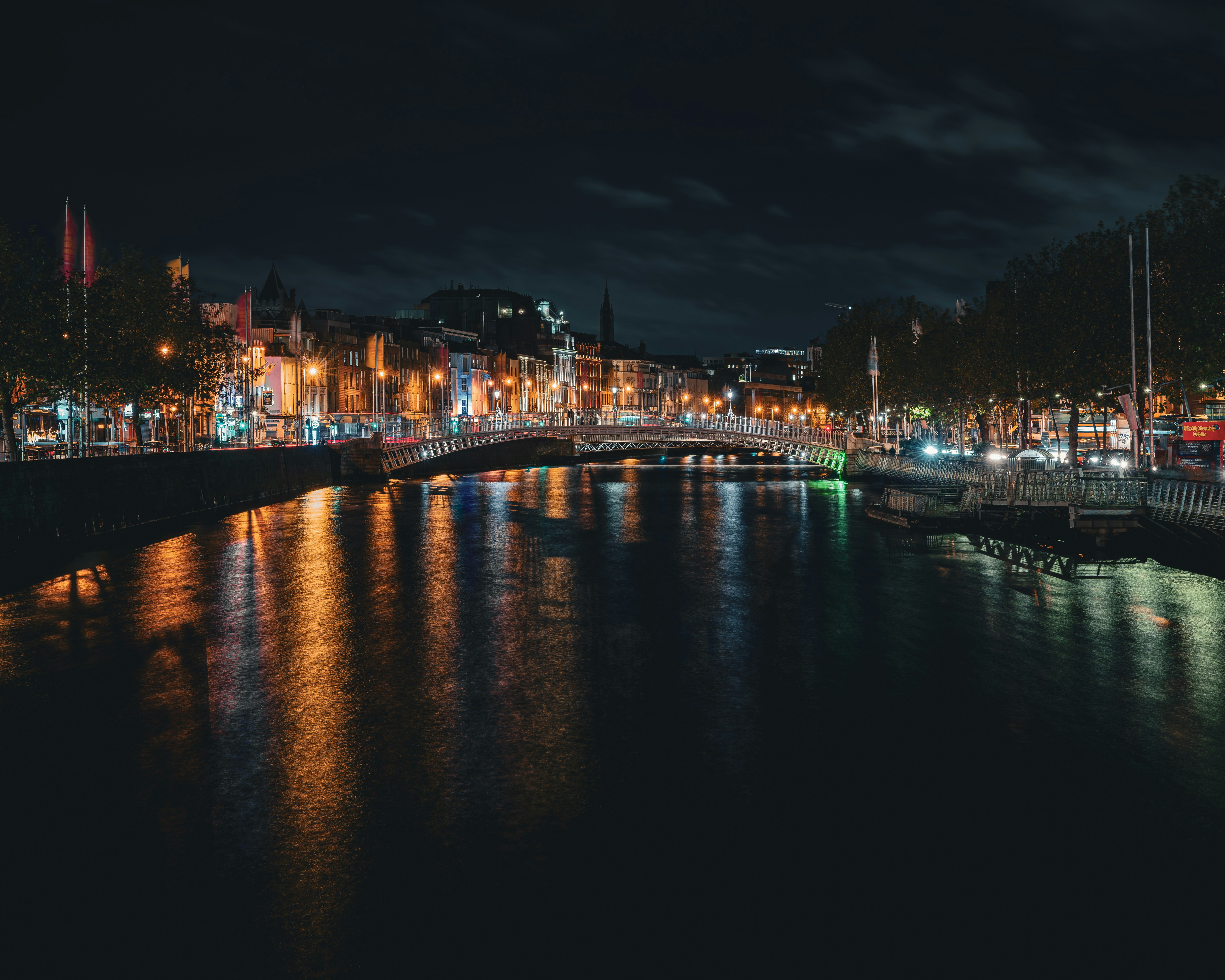 City lights reflecting on a dark river at night.