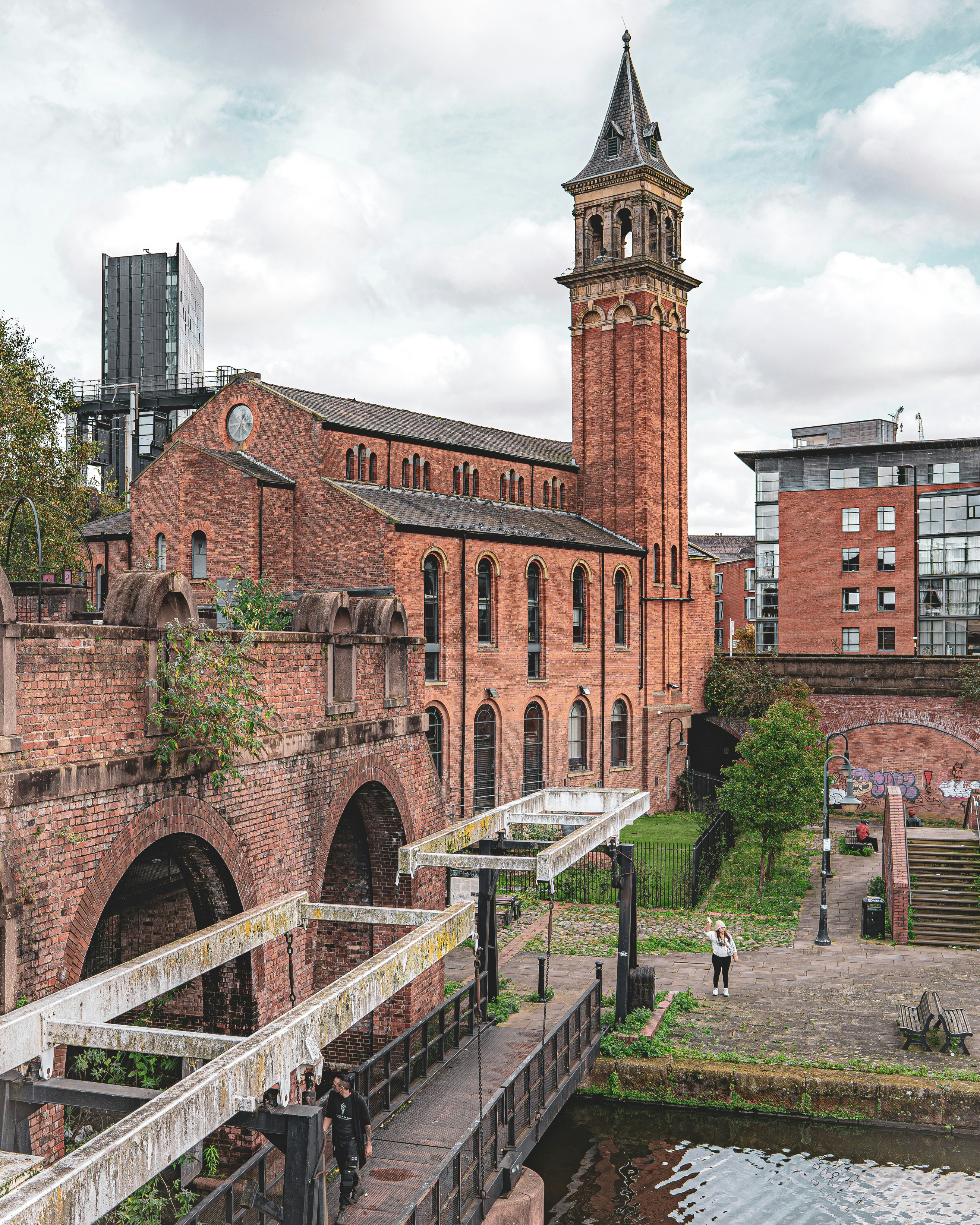 Historic brick building with a tall tower by canal
