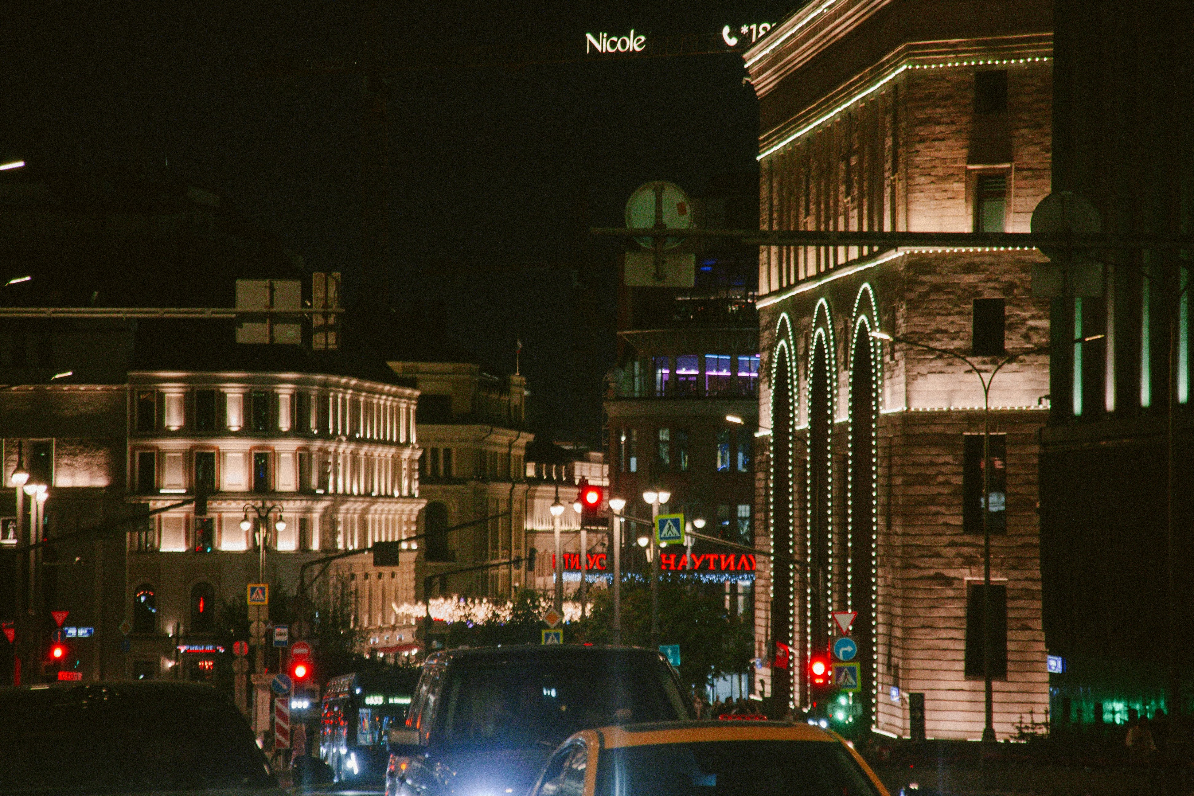 Cars driving on a street at night.