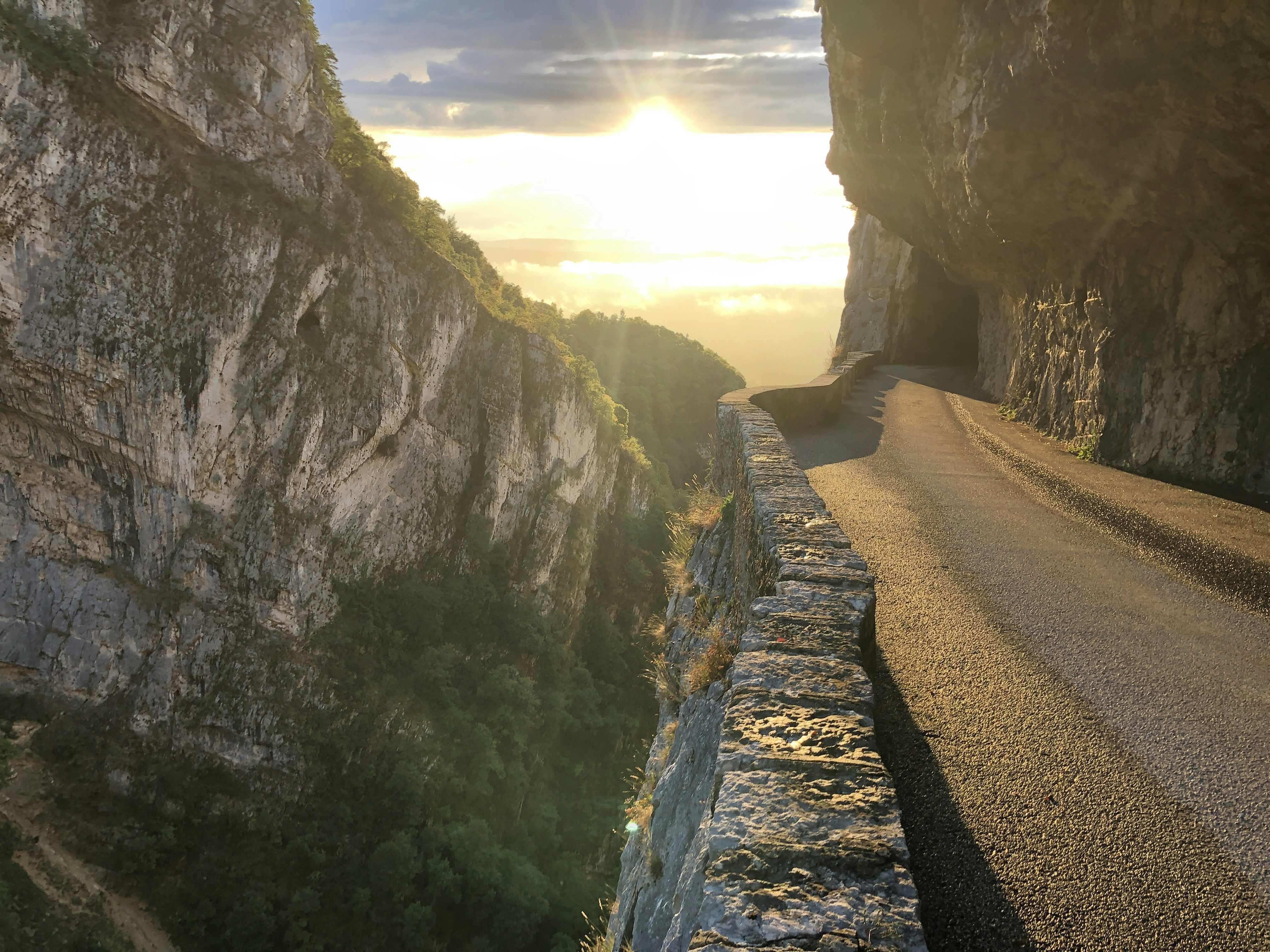 Mountain road at sunset with dramatic cliffs