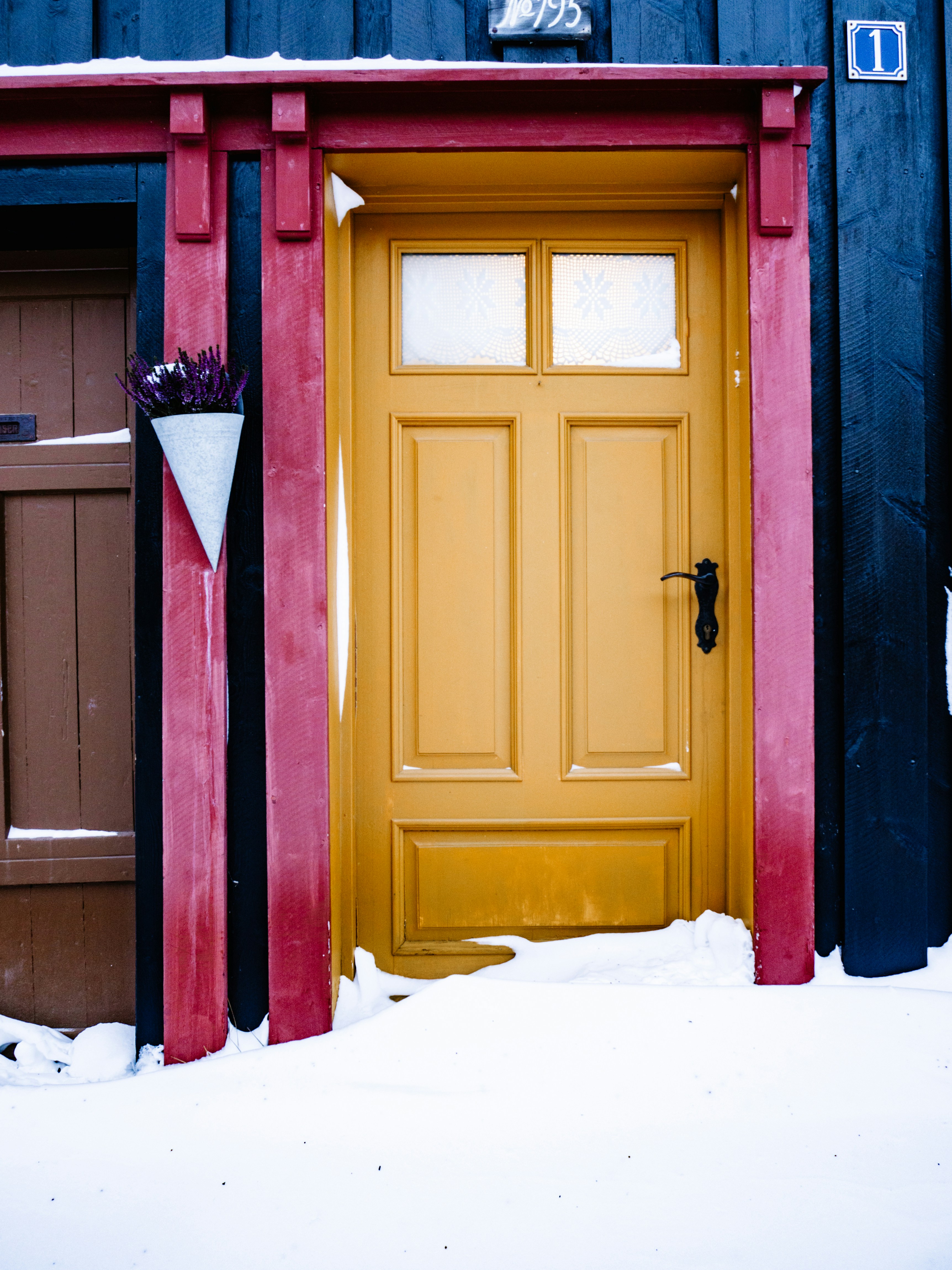 OLYMPUS DIGITAL CAMERA | Yellow door with red trim covered in snow.