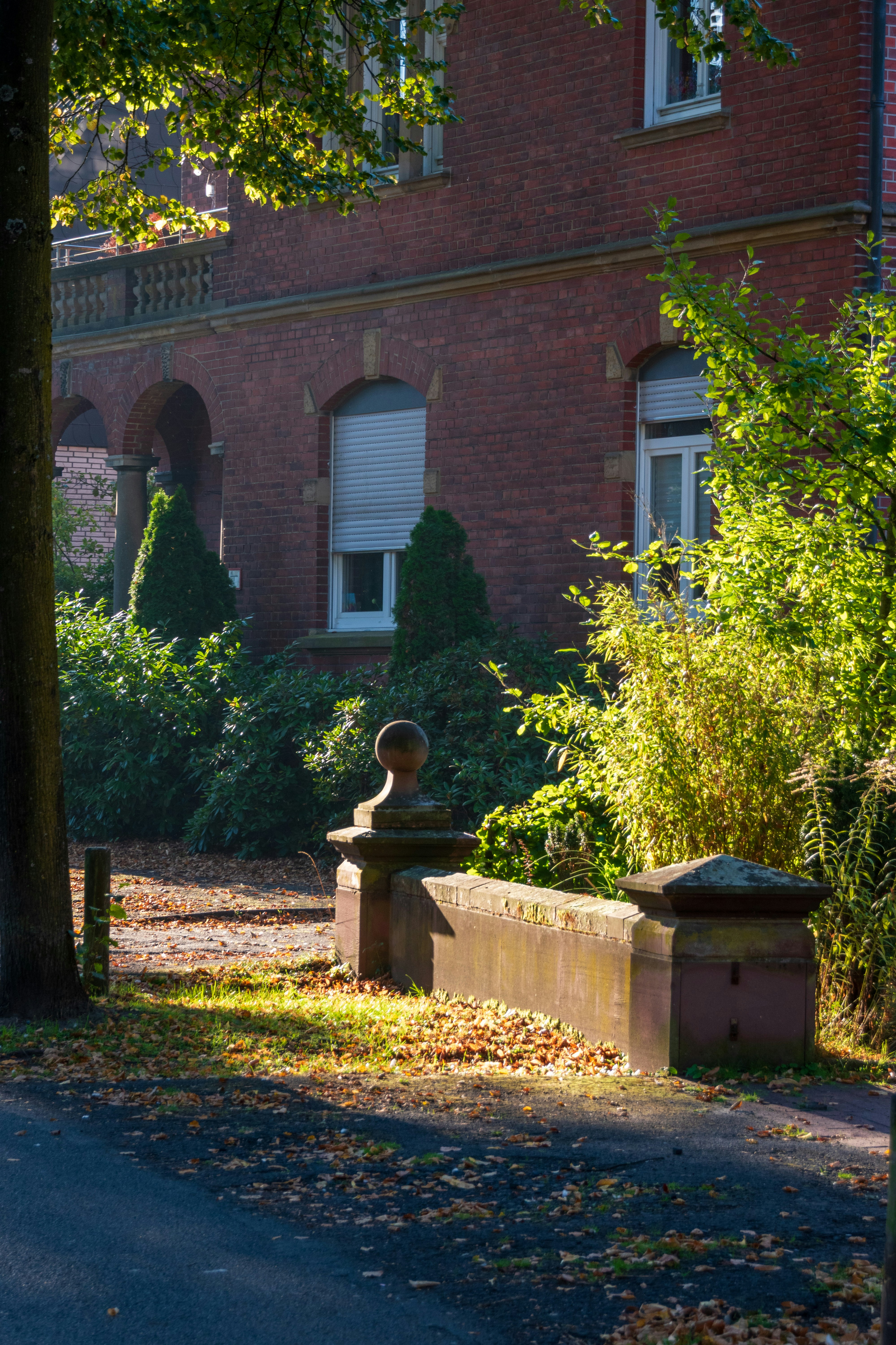Ball on a Pedestal Framed by Red Brick and Sunlit Foliage